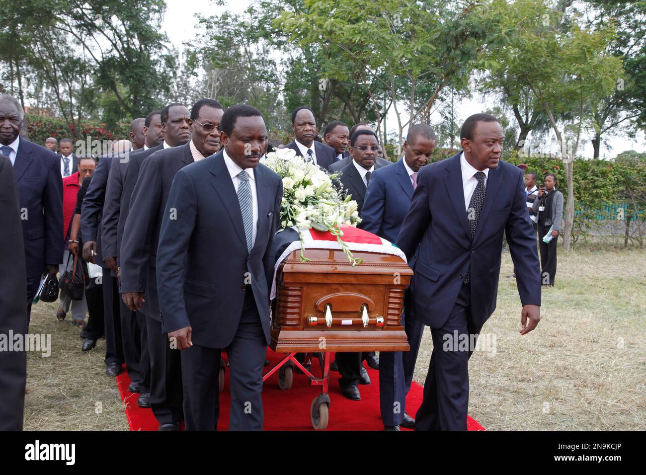 Kenyan cabinet ministers push the casket of the late minister for ...