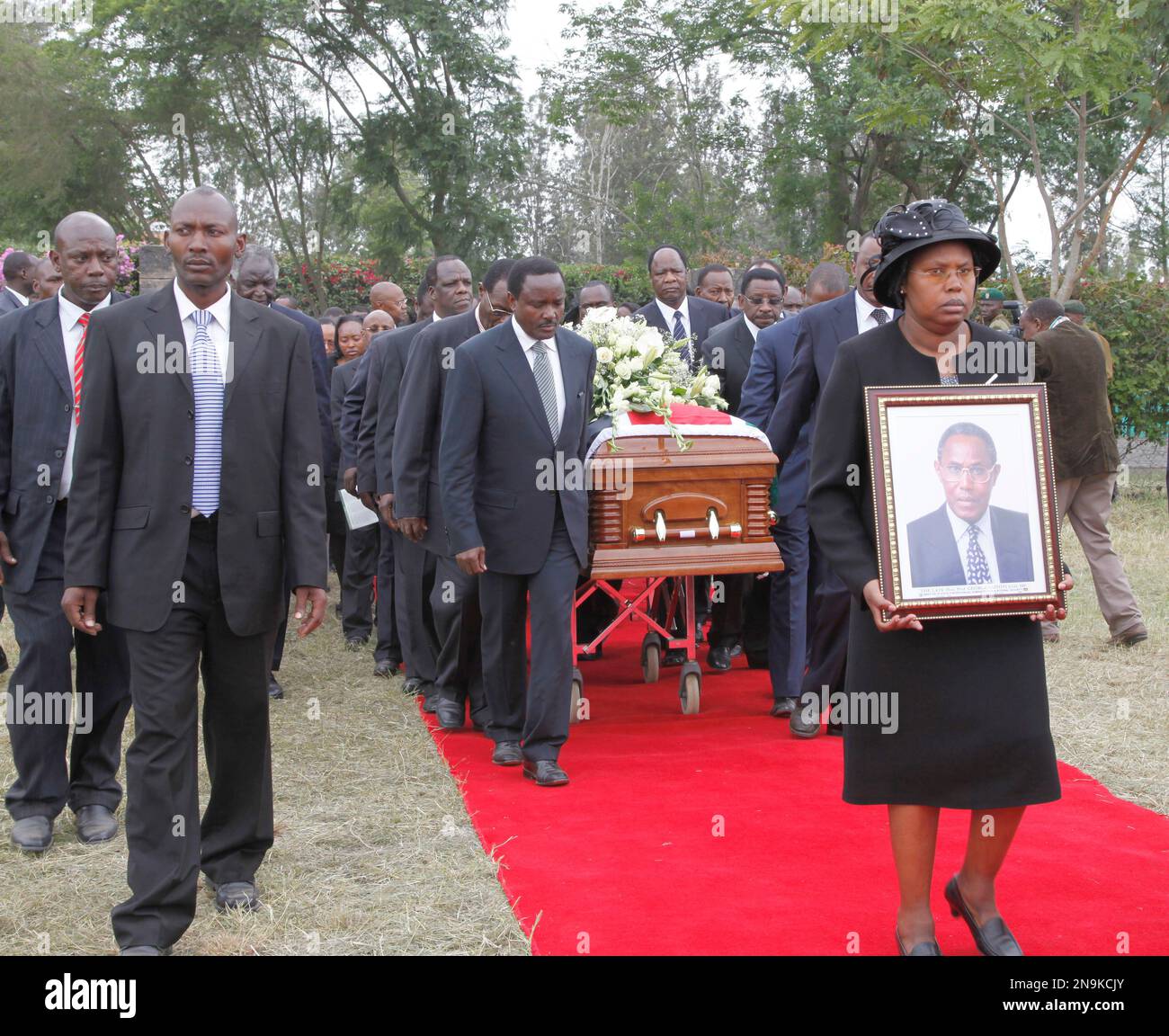 Kenyan cabinet ministers push the casket of the late minister for ...