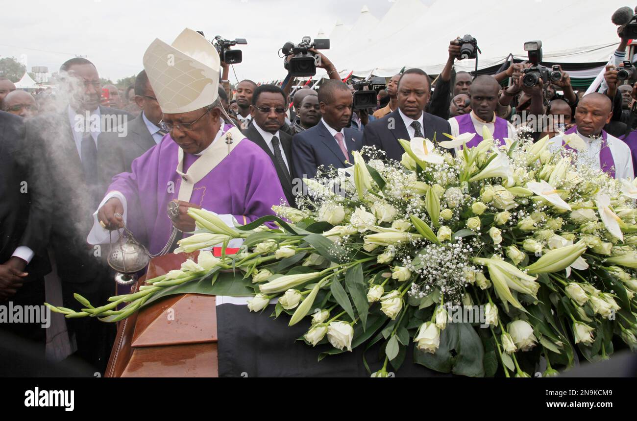 Cardinal John Njiu prays on the casket of the late minister for ...