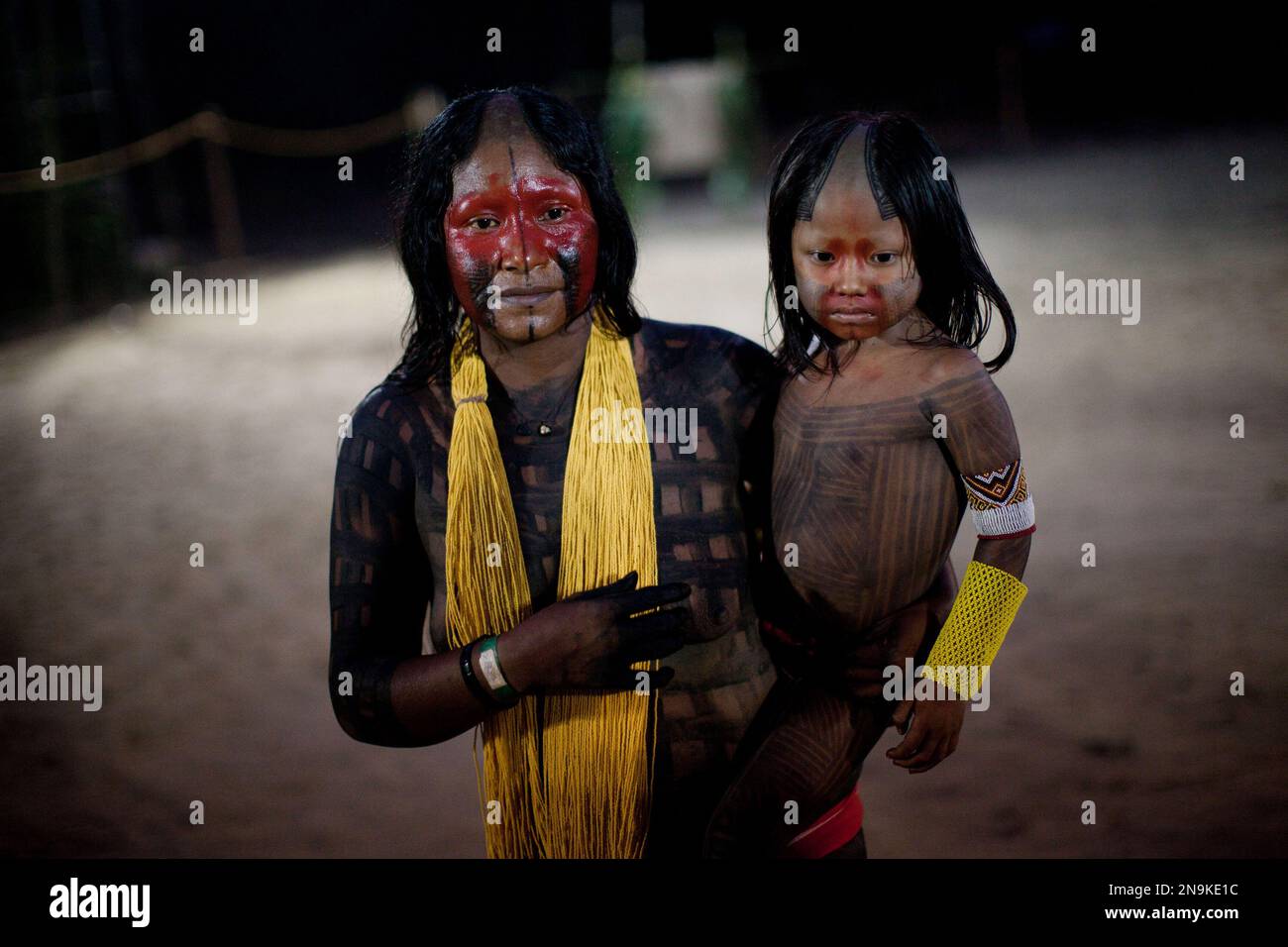A Kayapo tribe member carries a child in Kari-Oca village, where ...