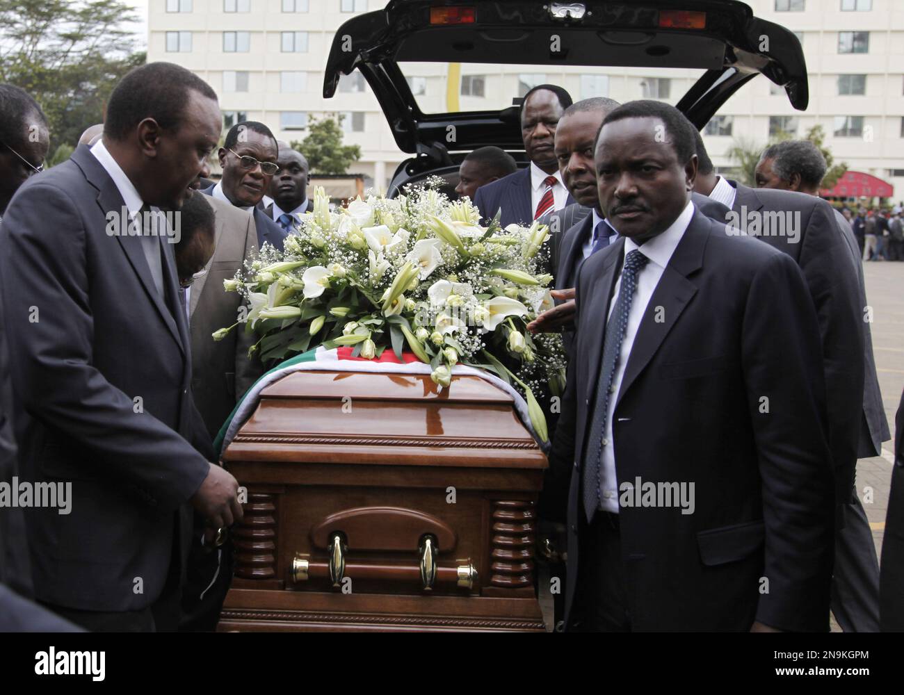 Kenyan cabinet ministers push the casket of the late minister for ...