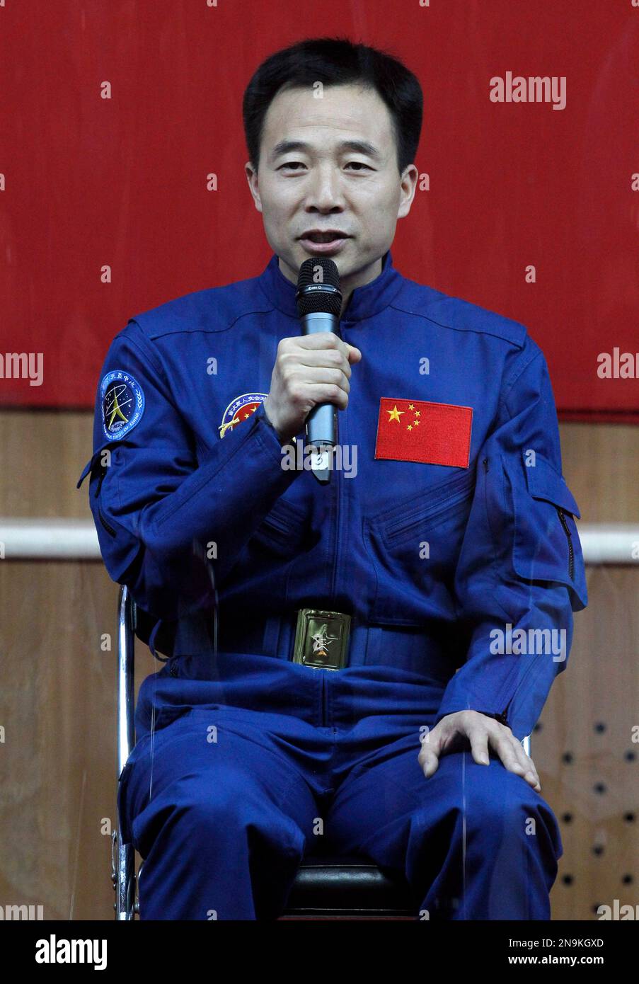 Chinese astronaut Jing Haipeng speaks from behind a glass enclosure ...