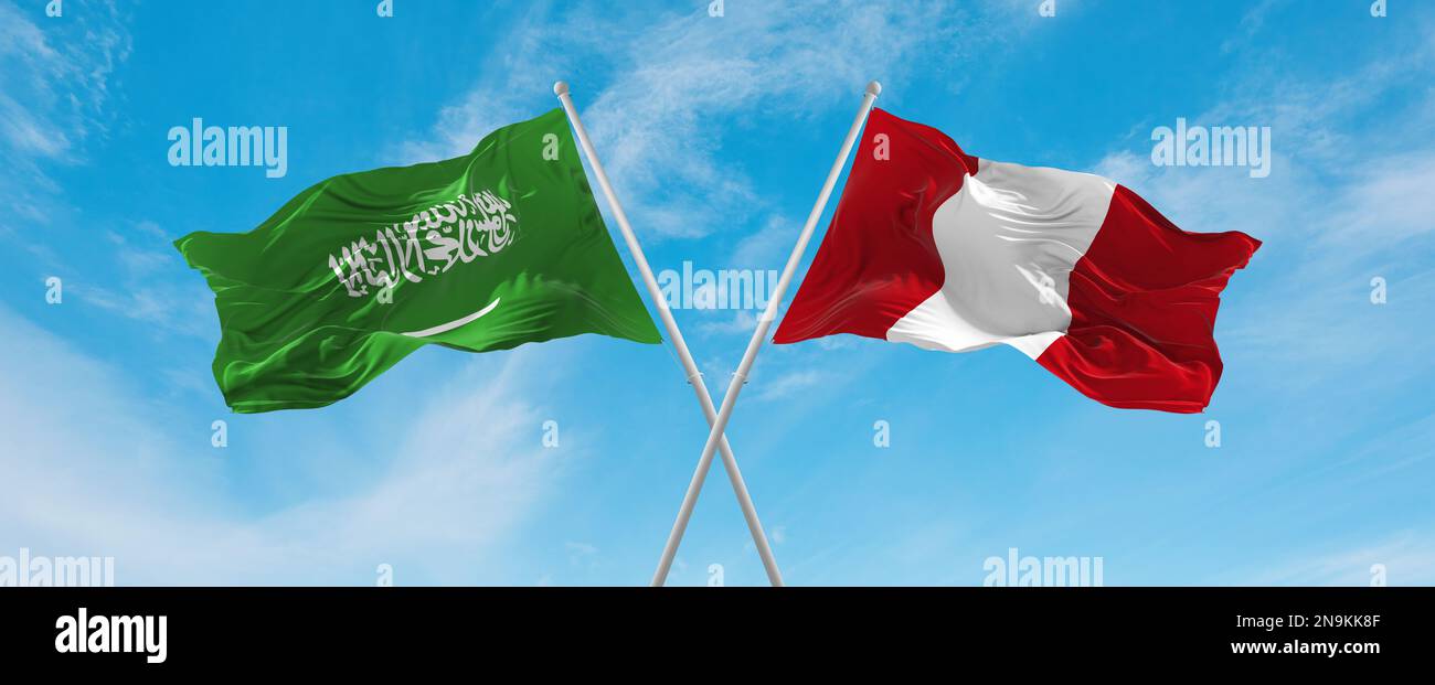 two crossed flags Peru and Saudi Arabia waving in wind at cloudy sky ...