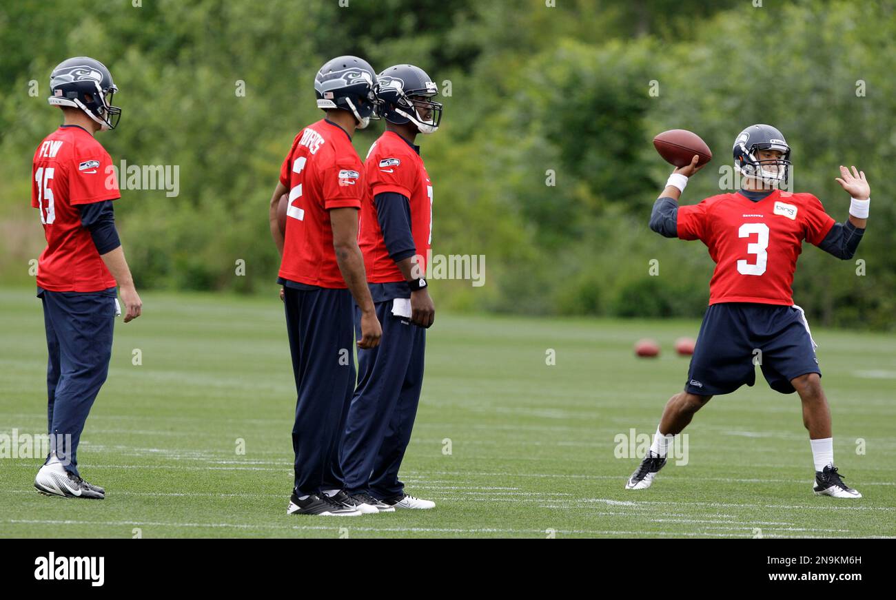 Seattle Seahawks quarterback Russell Wilson, right, passes as fellow ...