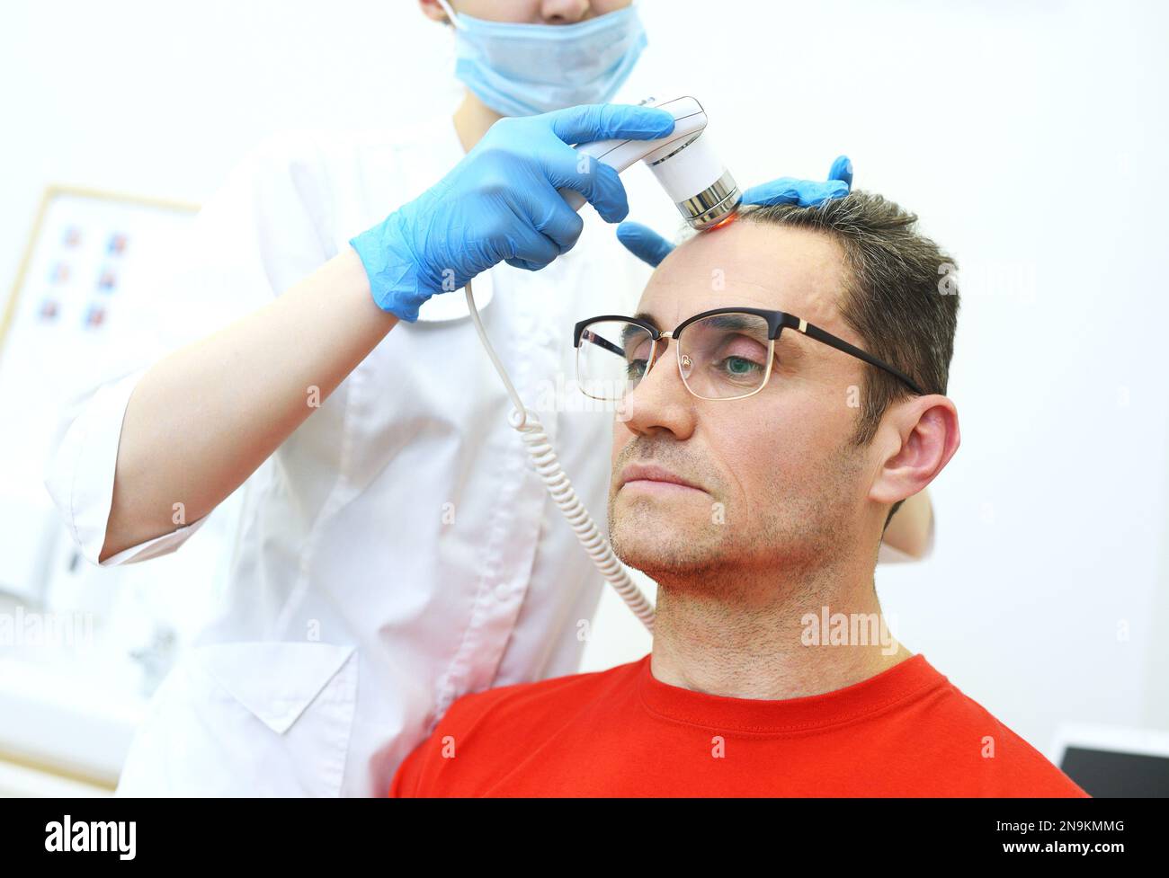 A cosmetologist-trichologist diagnoses the condition of a male patient ...