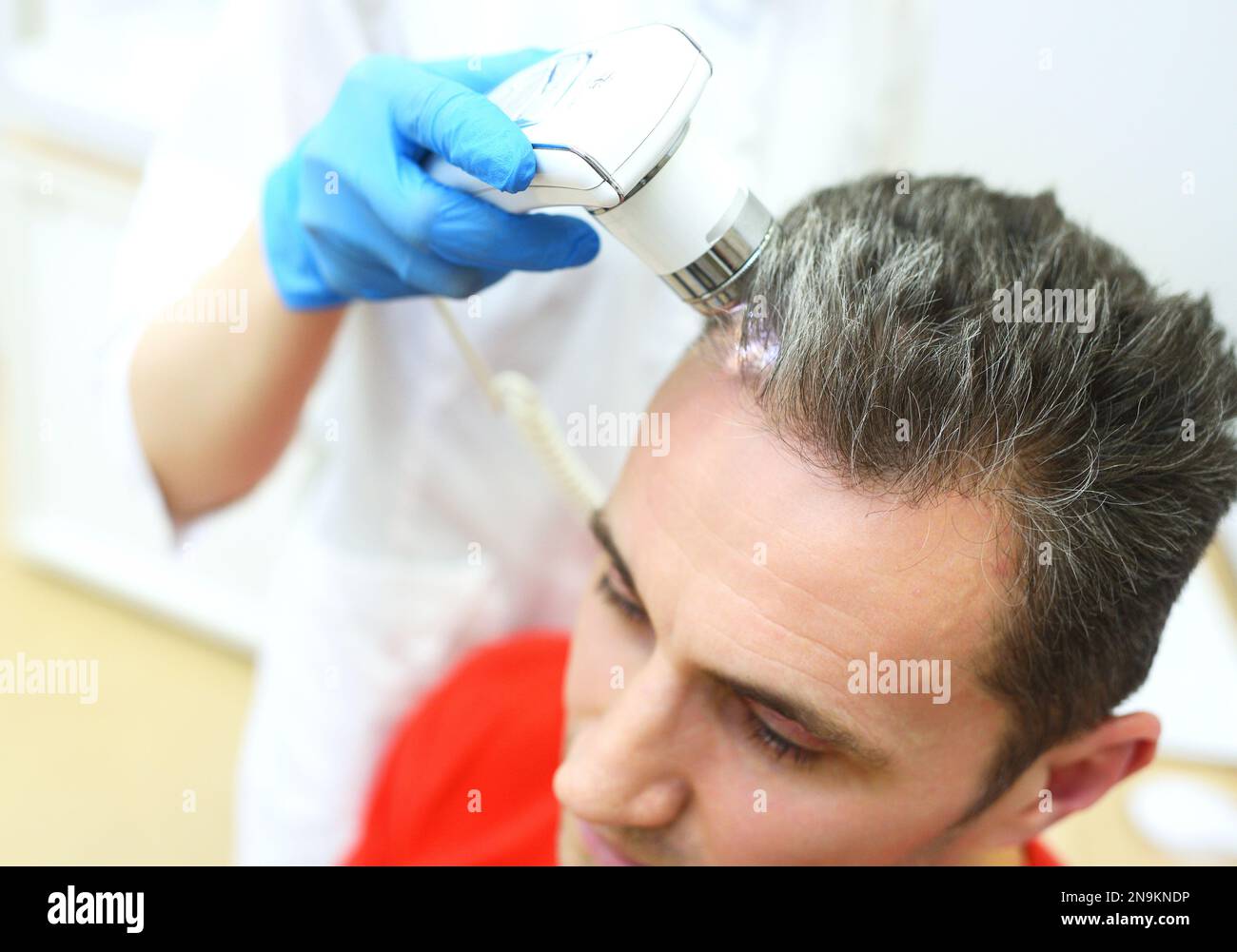 A cosmetologist-trichologist diagnoses the condition of a male patient ...