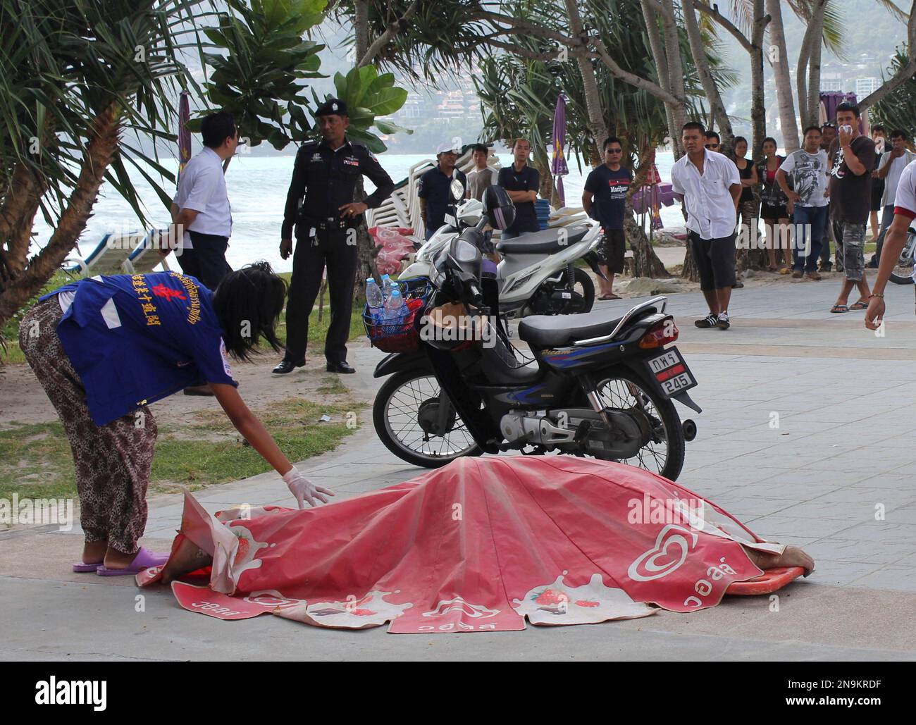 A Thai charity worker secures the body of Joshua Shane after he washed ...