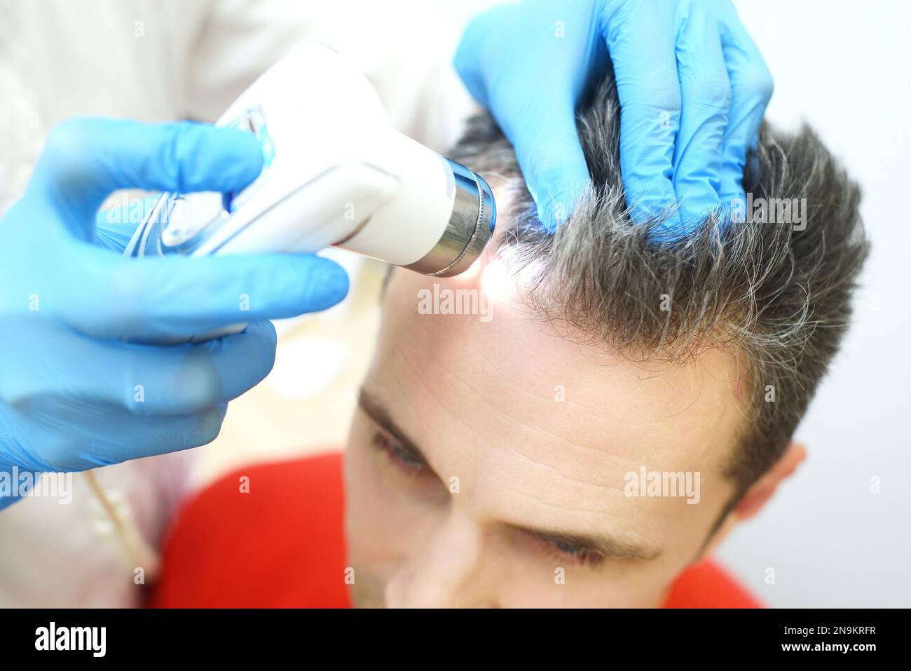 A cosmetologist-trichologist diagnoses the condition of a male patient ...