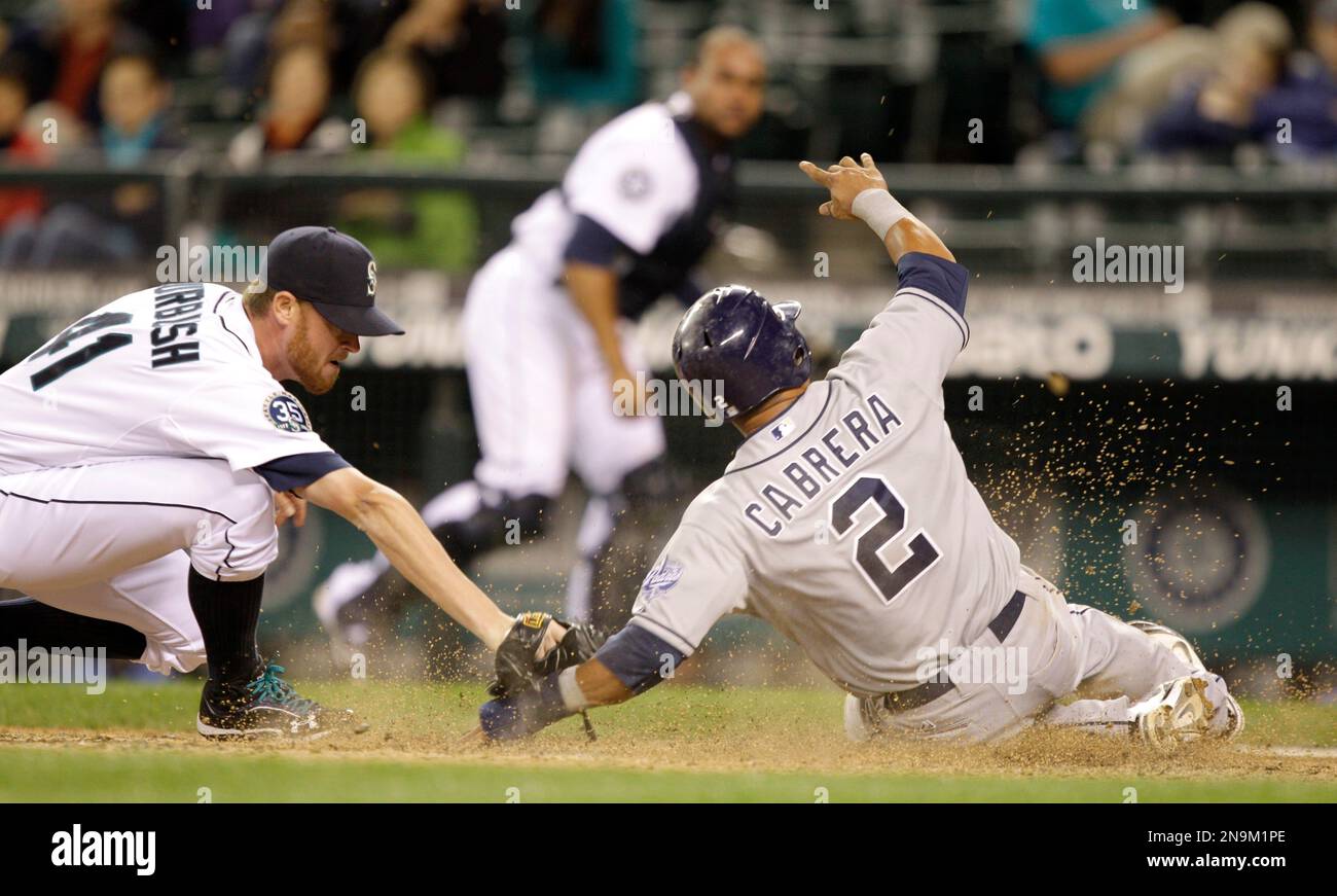 As catcher Miguel Olivo watches in the background Seattle Mariners ...