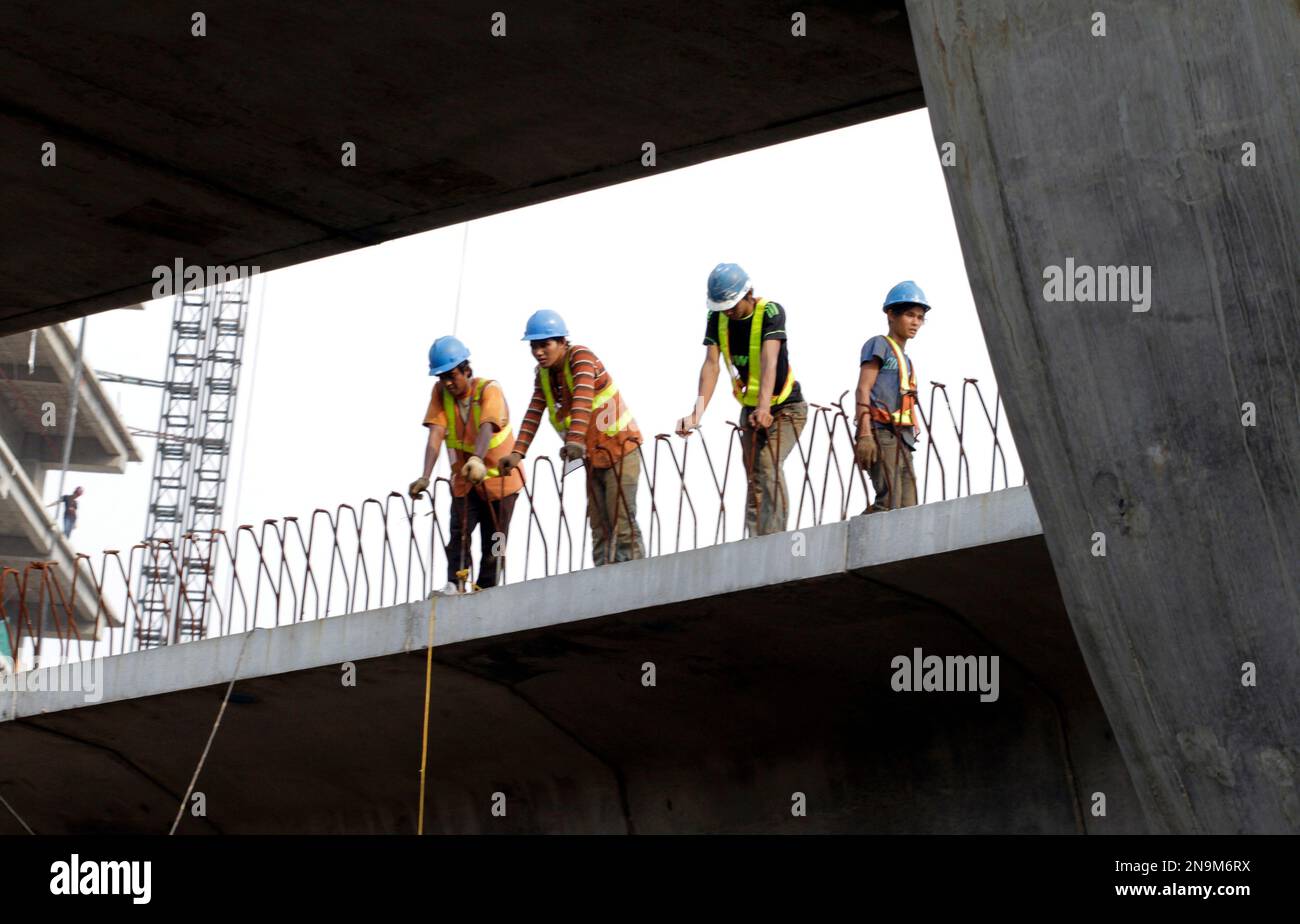 Workers stand at a bridge construction site in Jakarta, Indonesia ...