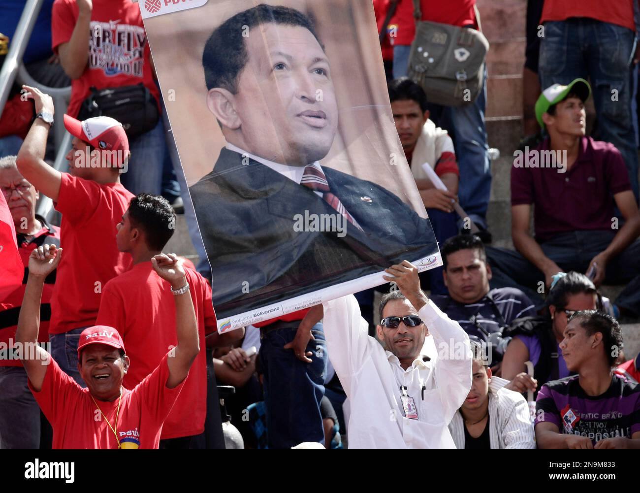 Supporters of Venezuela's President Hugo Chavez, one holding up an ...