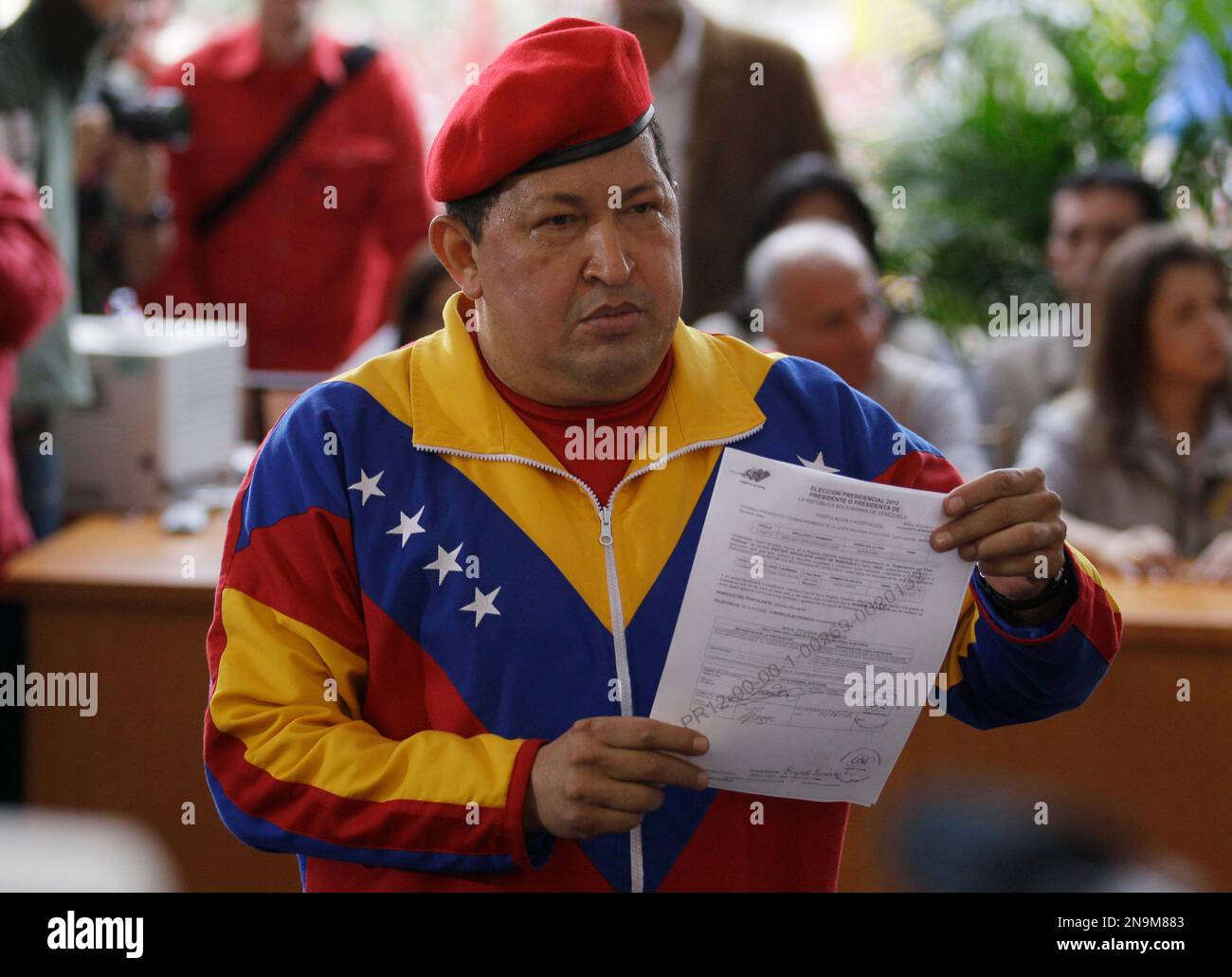 Venezuela's President Hugo Chavez shows a registration certificate as ...