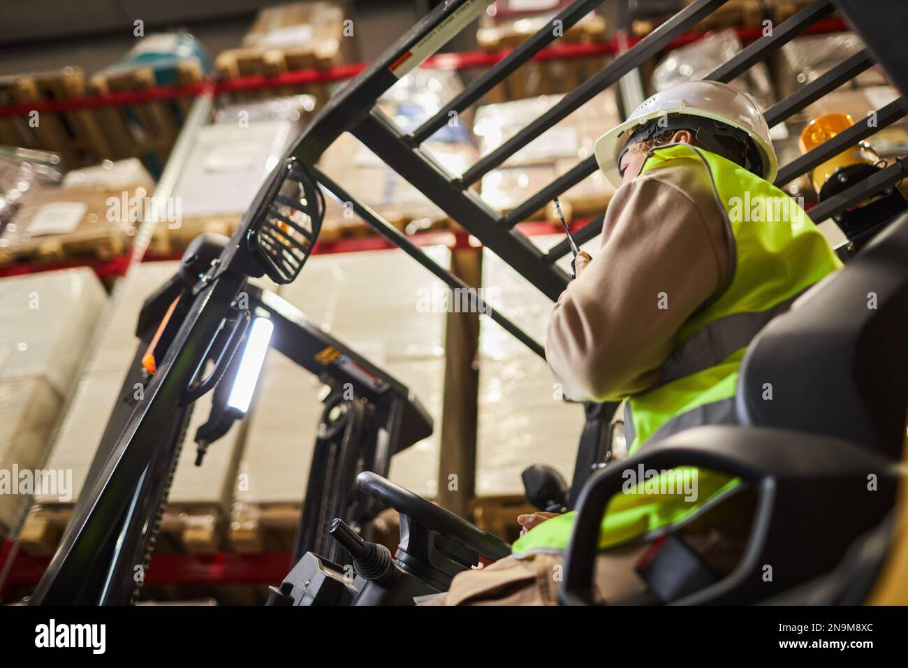 Low angle view of female worker wearing hardhat while operating ...