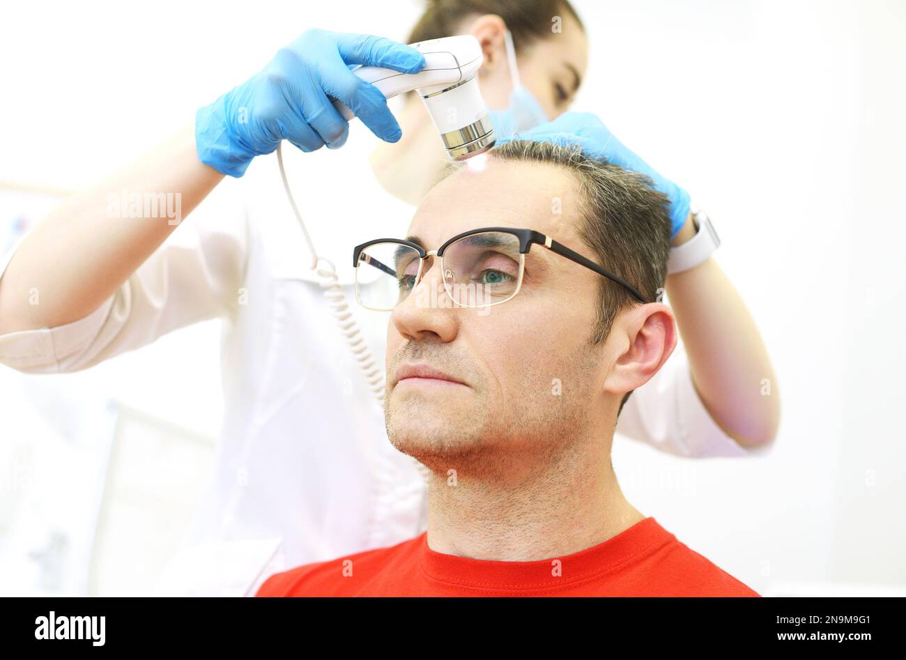A cosmetologist-trichologist diagnoses the condition of a male patient ...