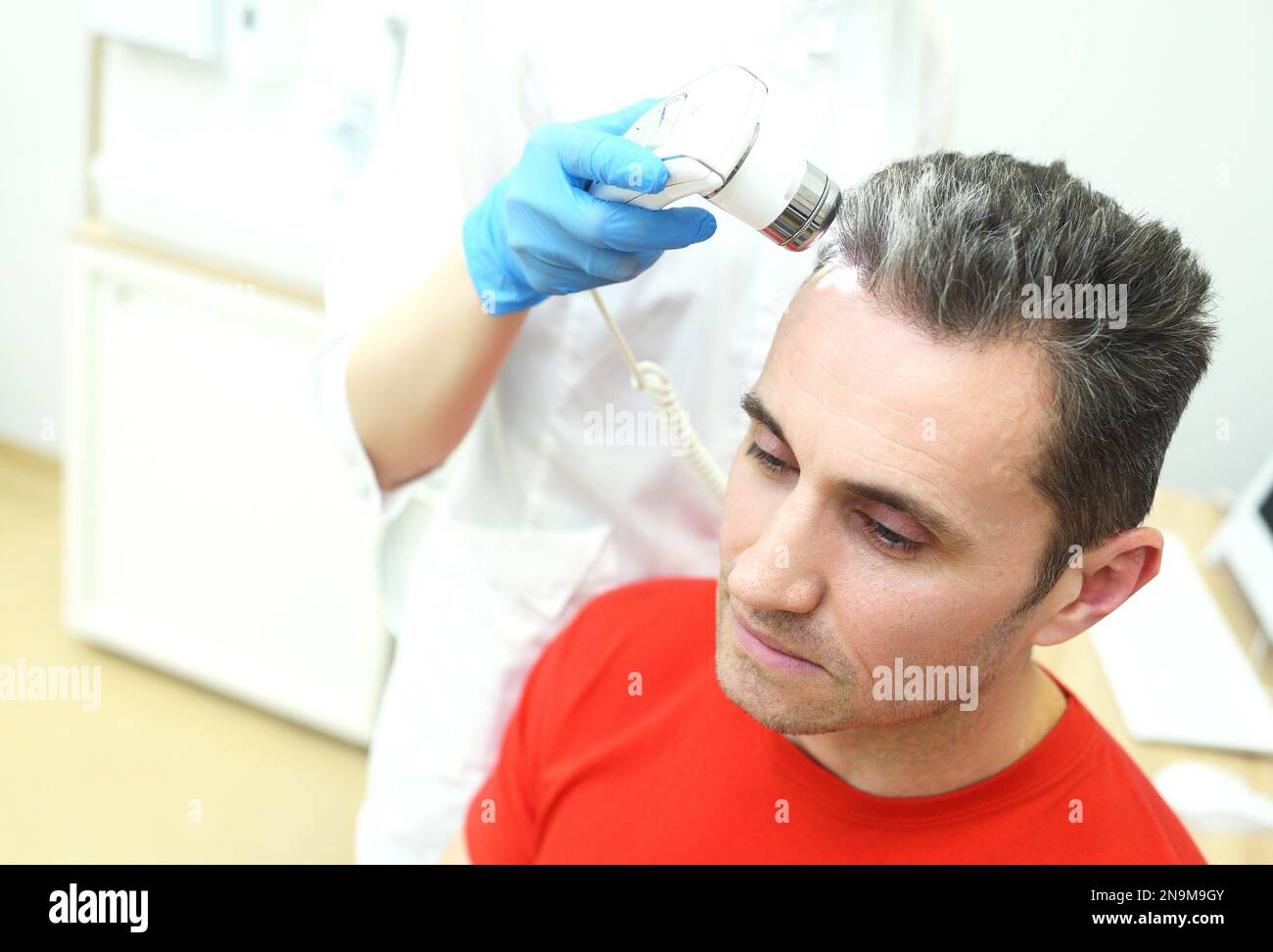 A cosmetologist-trichologist diagnoses the condition of a male patient ...