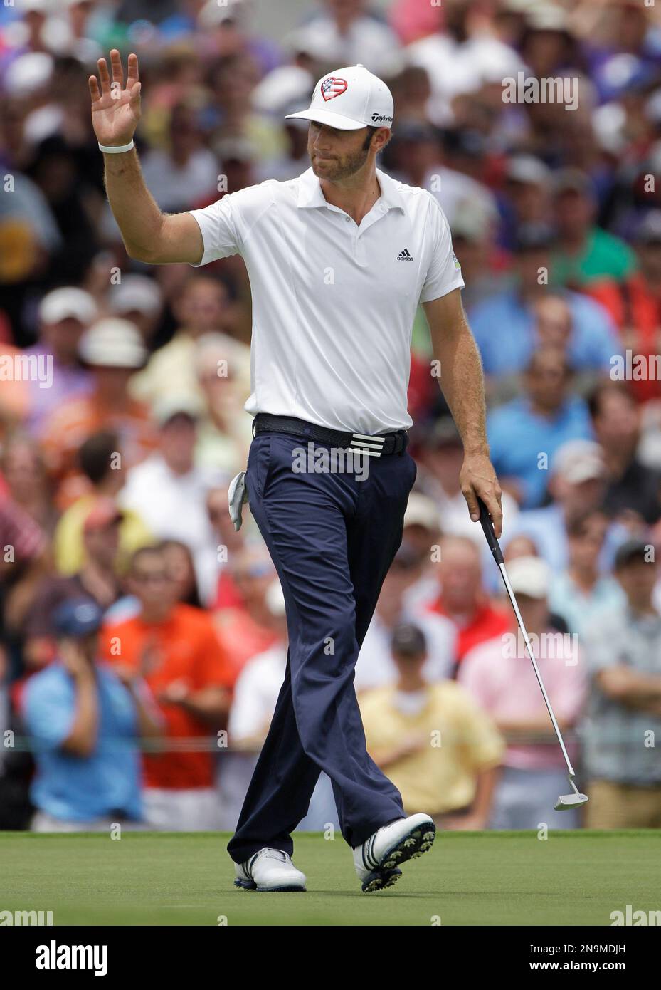 Dustin Johnson waves to the crowd as he leaves the 18th green during ...