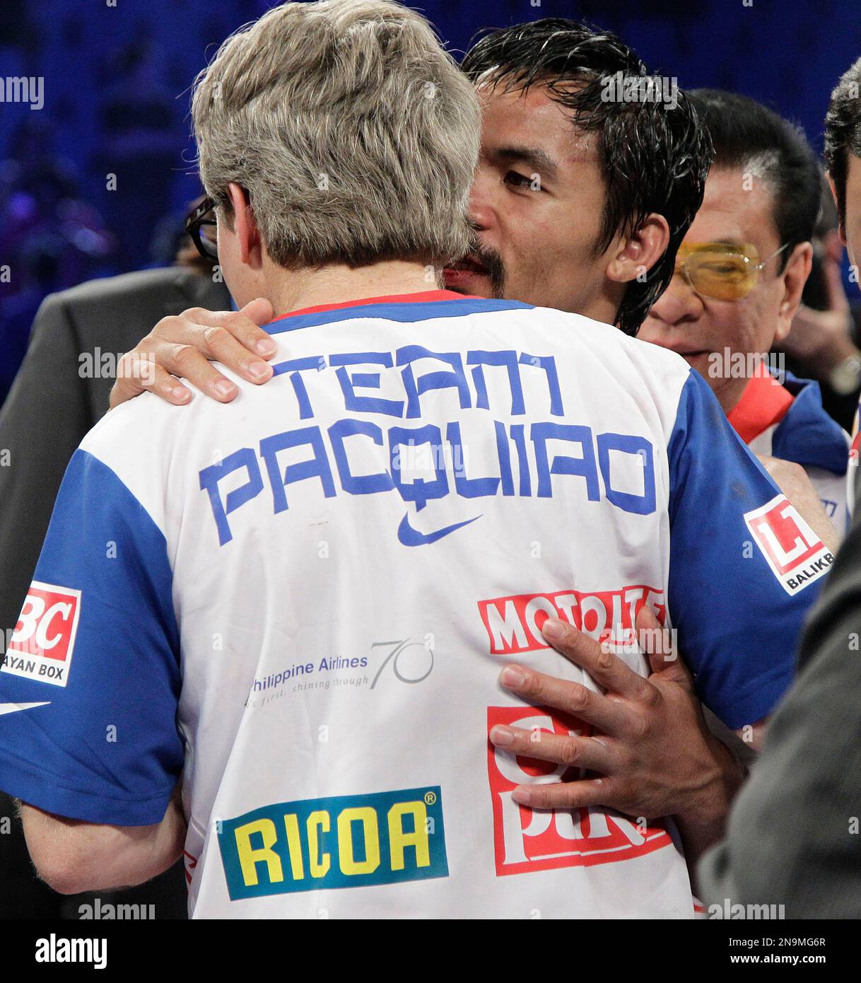 Manny Pacquiao, from the Philippines, right, whispers in the ear of his ...