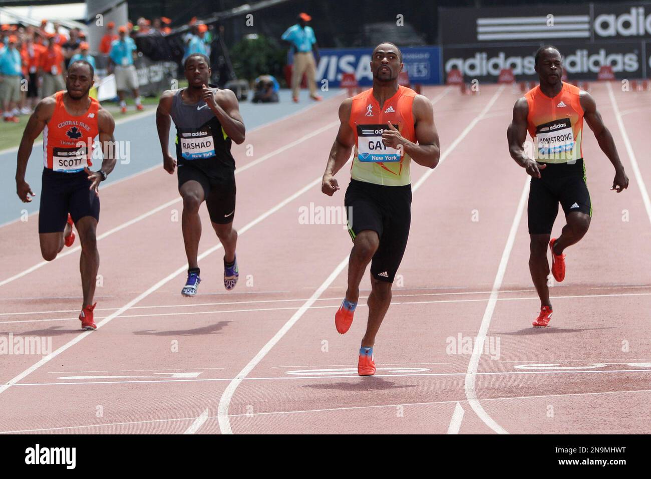 Tyson Gay, second from right, crosses the finish line ahead of the pack ...