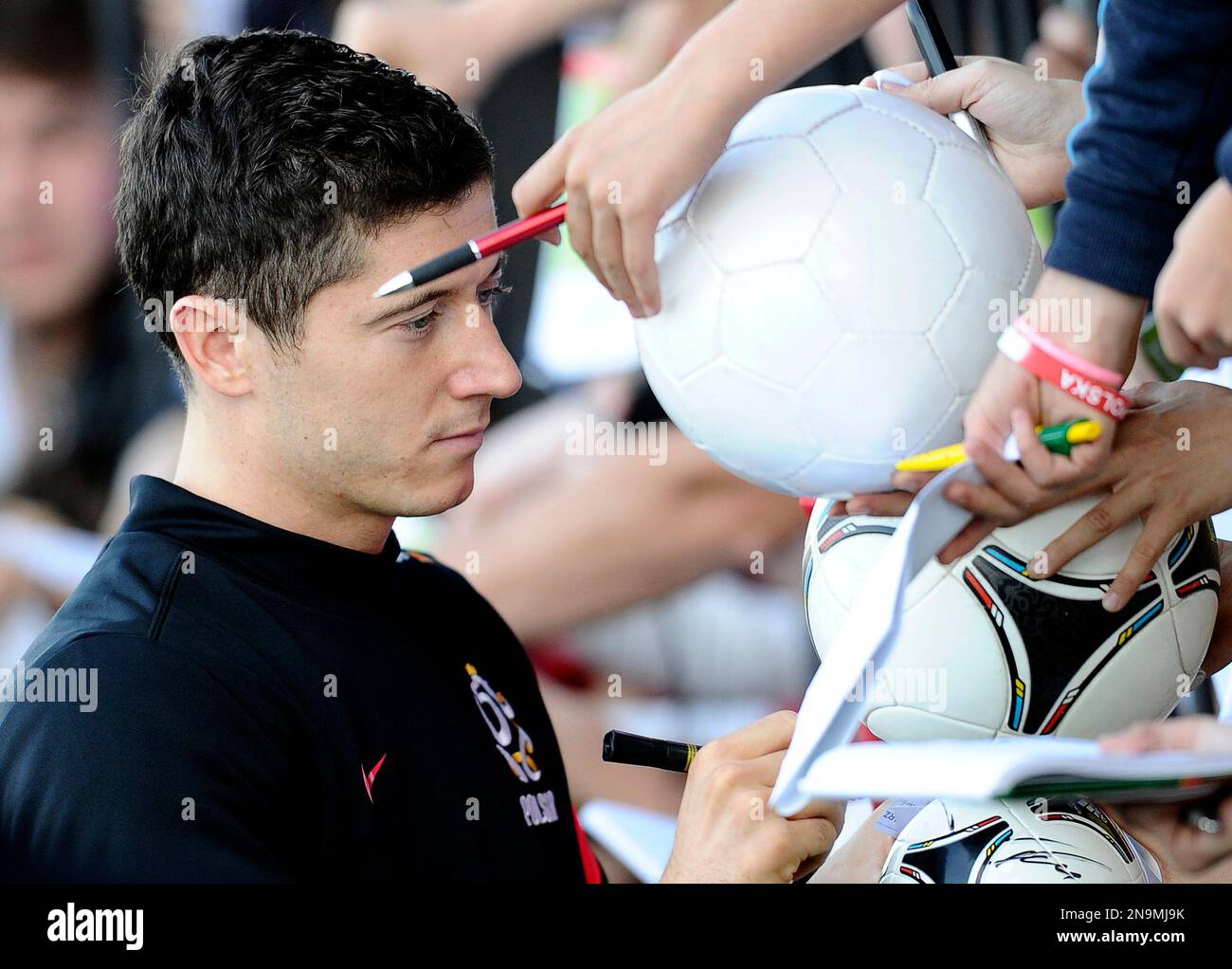 Poland's Robert Lewandowski signs autographs to fans after a training ...