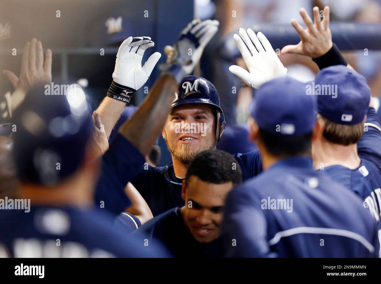 Milwaukee Brewers' Corey Hart, center, is greeted in the dugout by ...