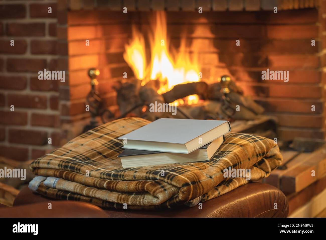 Books on top of a blanket in front of the cozy fire of the fireplace in ...