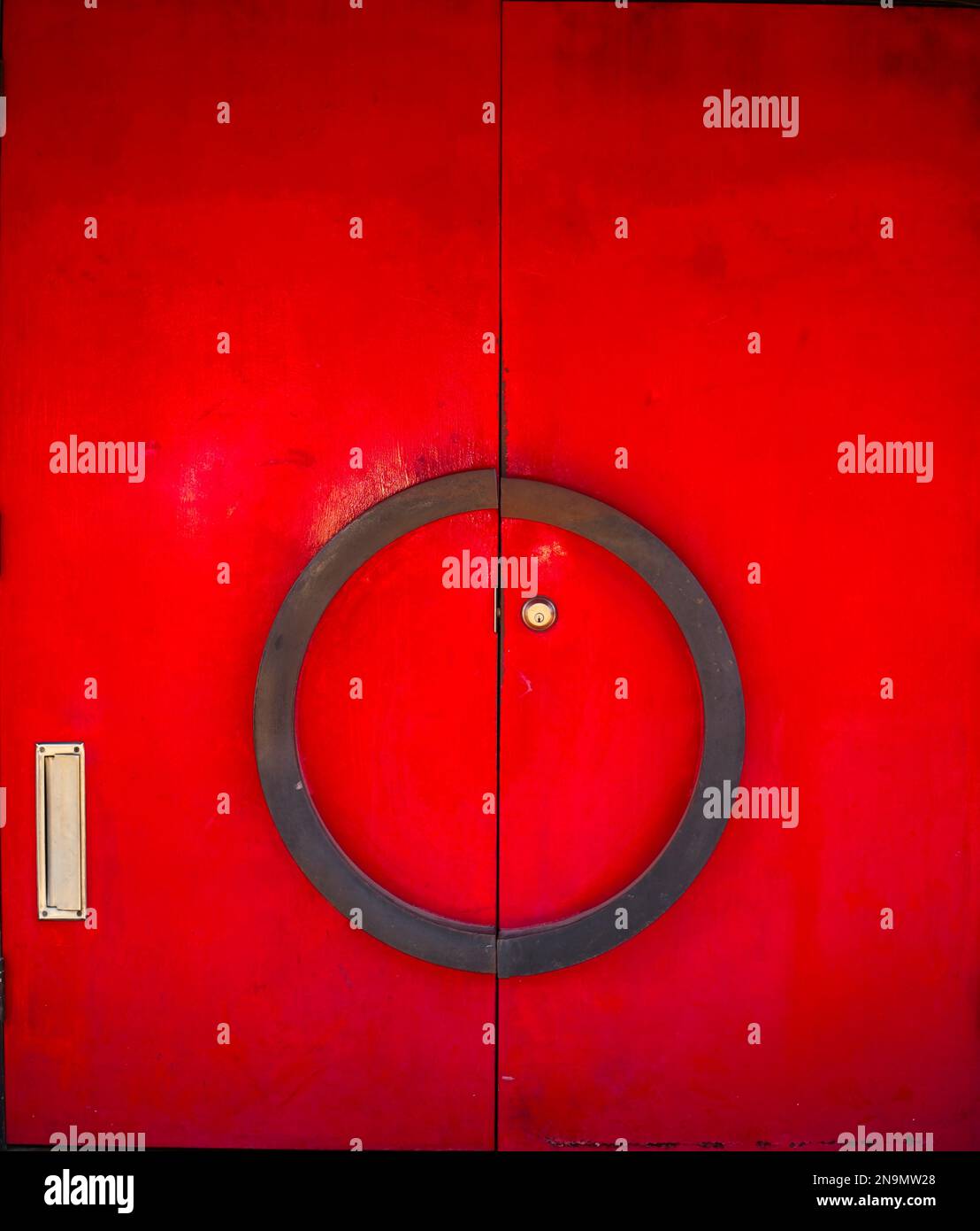 Bright red door with a large circular metal door, handle Stock Photo ...