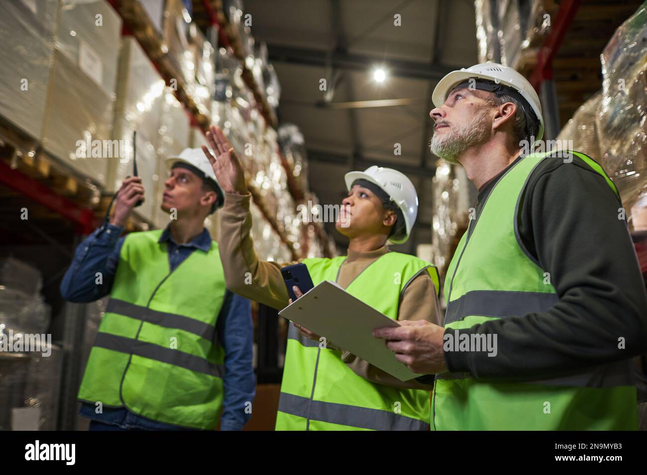 Low angle at group of workers in warehouse doing stock review and ...