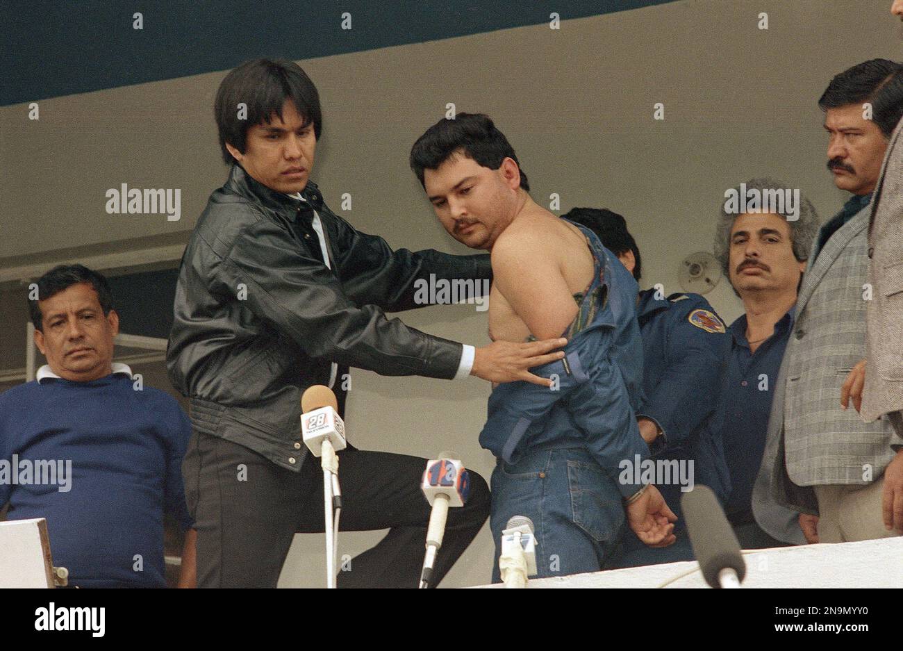 Mexican police pull the shirt off of Elio Hernandez Rivera, right, a suspect in the Matamoros ...