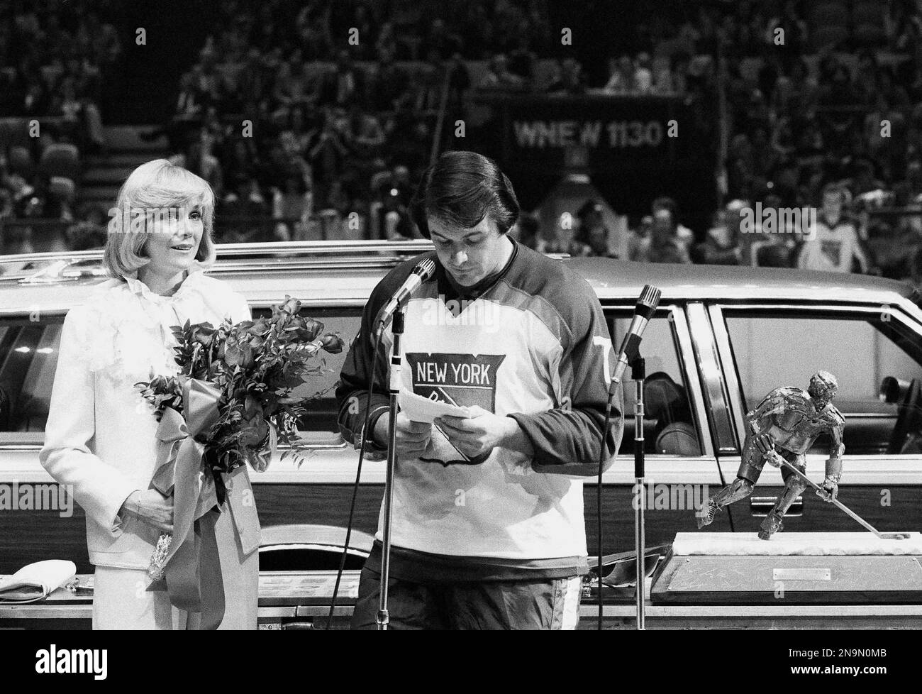 Rod Gilbert speaks as his wife Judy stands by holding a bouquet of ...