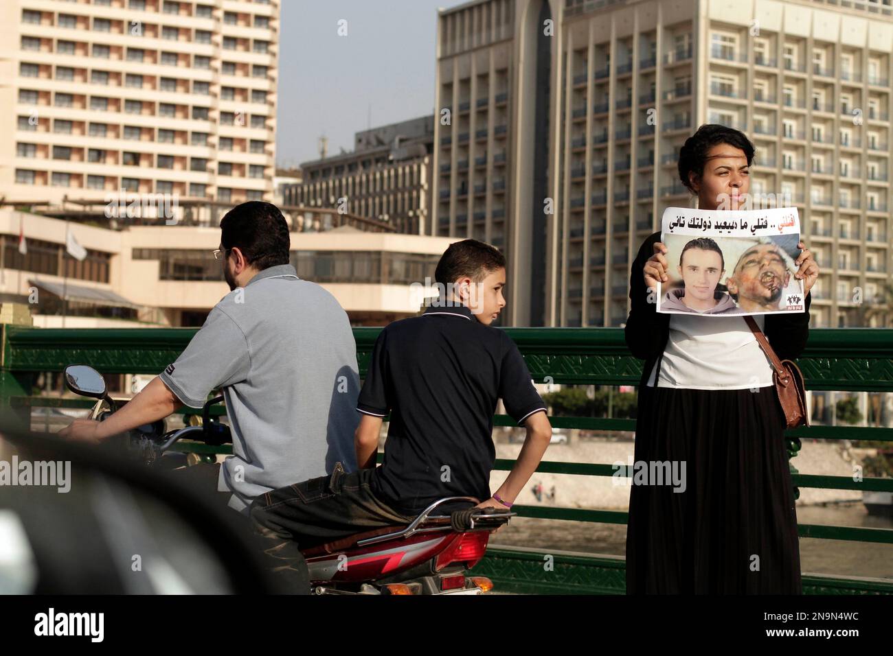 An Egyptian woman holds a poster which purports to show Khaled Said ...