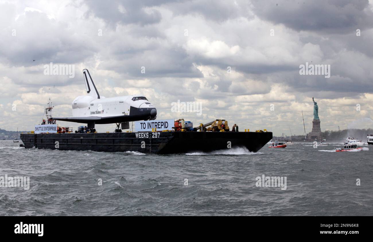 The space shuttle Enterprise passes the Statue of Liberty as it makes ...