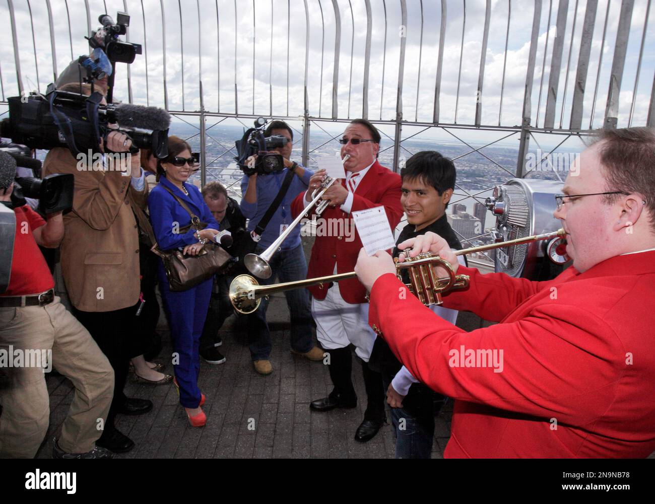 Sam Grossman, known as Sam the Bugler, center, Mario Gutierrez, from ...