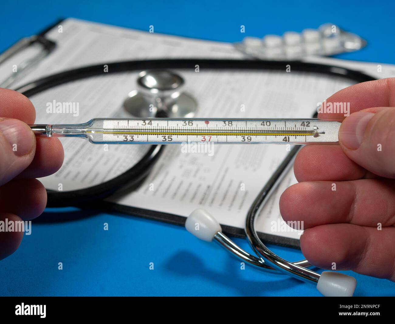 The doctor holds in his hands a thermometer used to measure the ...