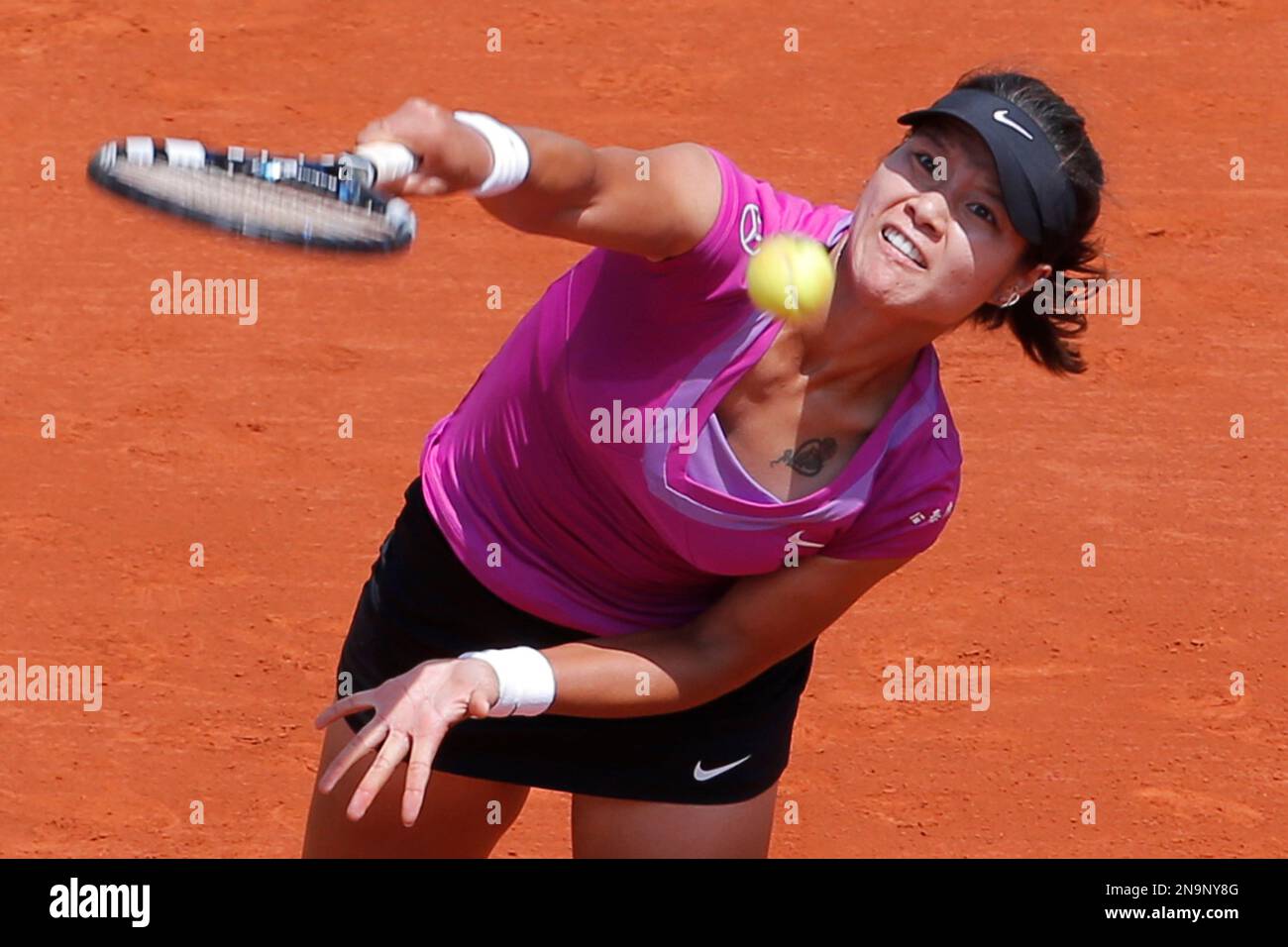 Li Na of China serves in her third round match against Christina McHale ...