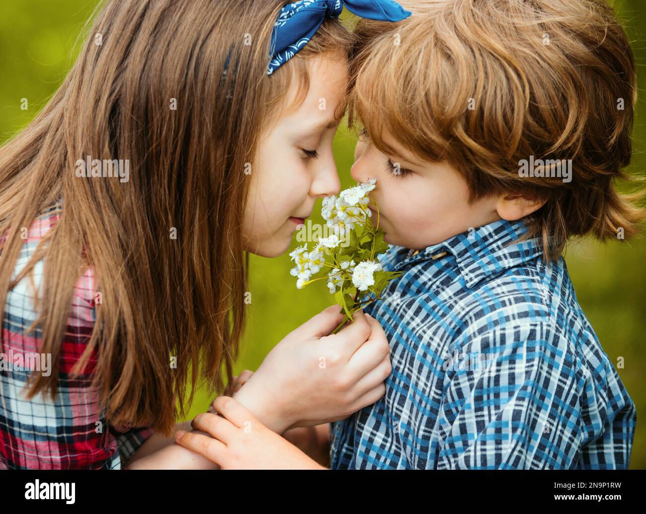Cute kids blowing dandelion. Children sitting on a meadow blowing ...
