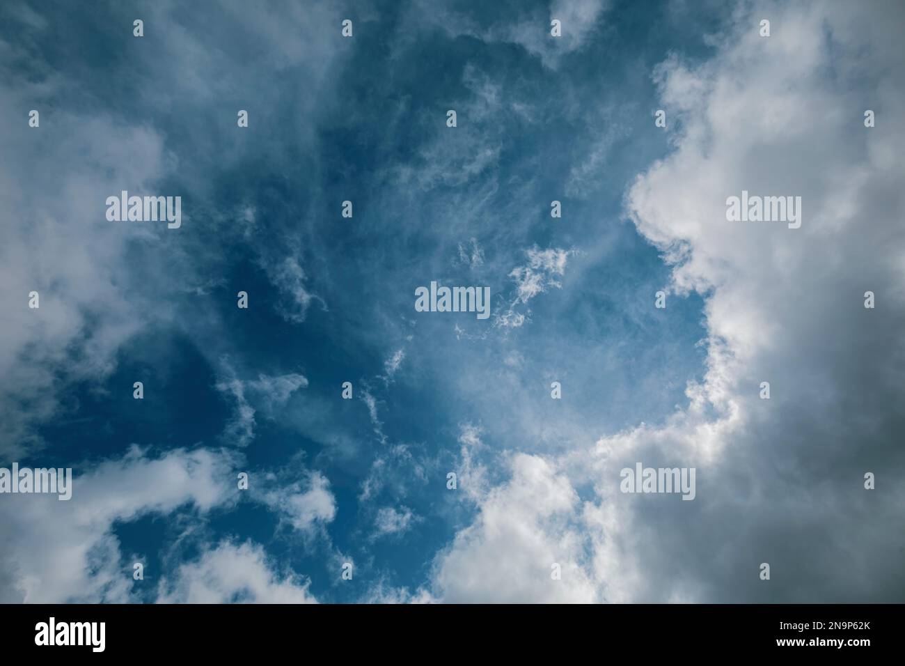 Intense blue sky with fluffy white and greyish storm clouds and intense ...