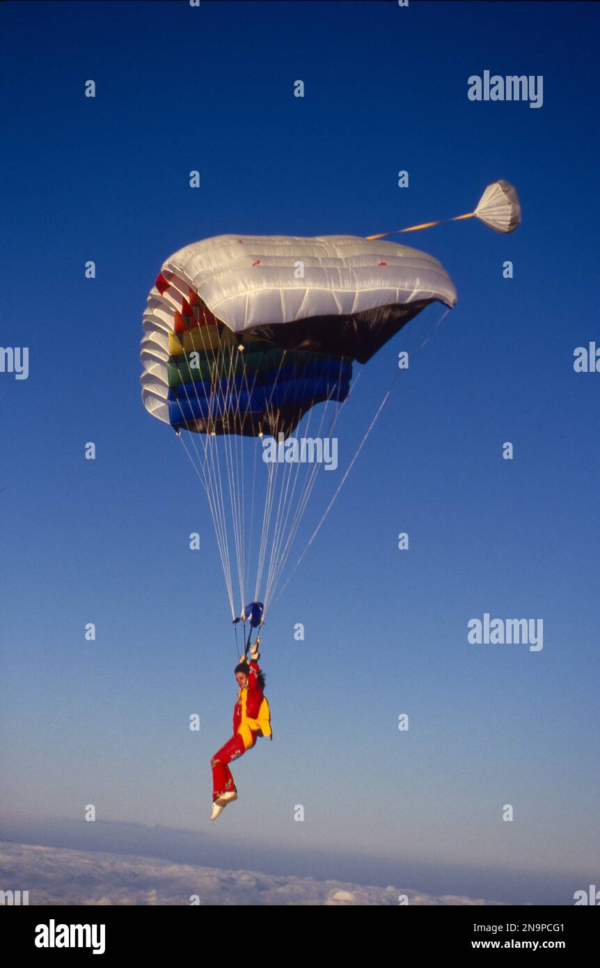 Parachutist falling from the sky with chute open Stock Photo - Alamy