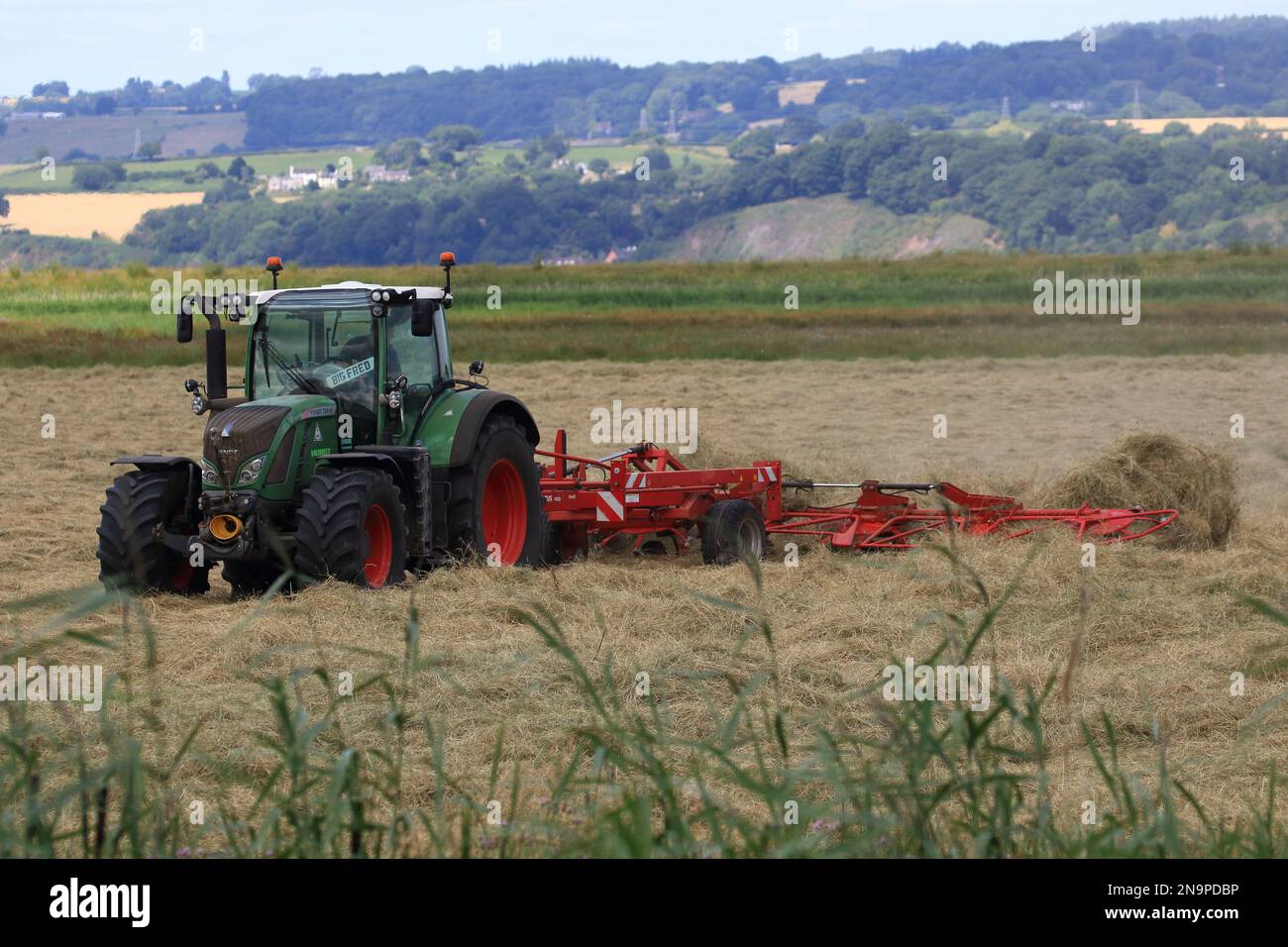 Making hay. Tractor turning hay near Slimbridge Stock Photo - Alamy