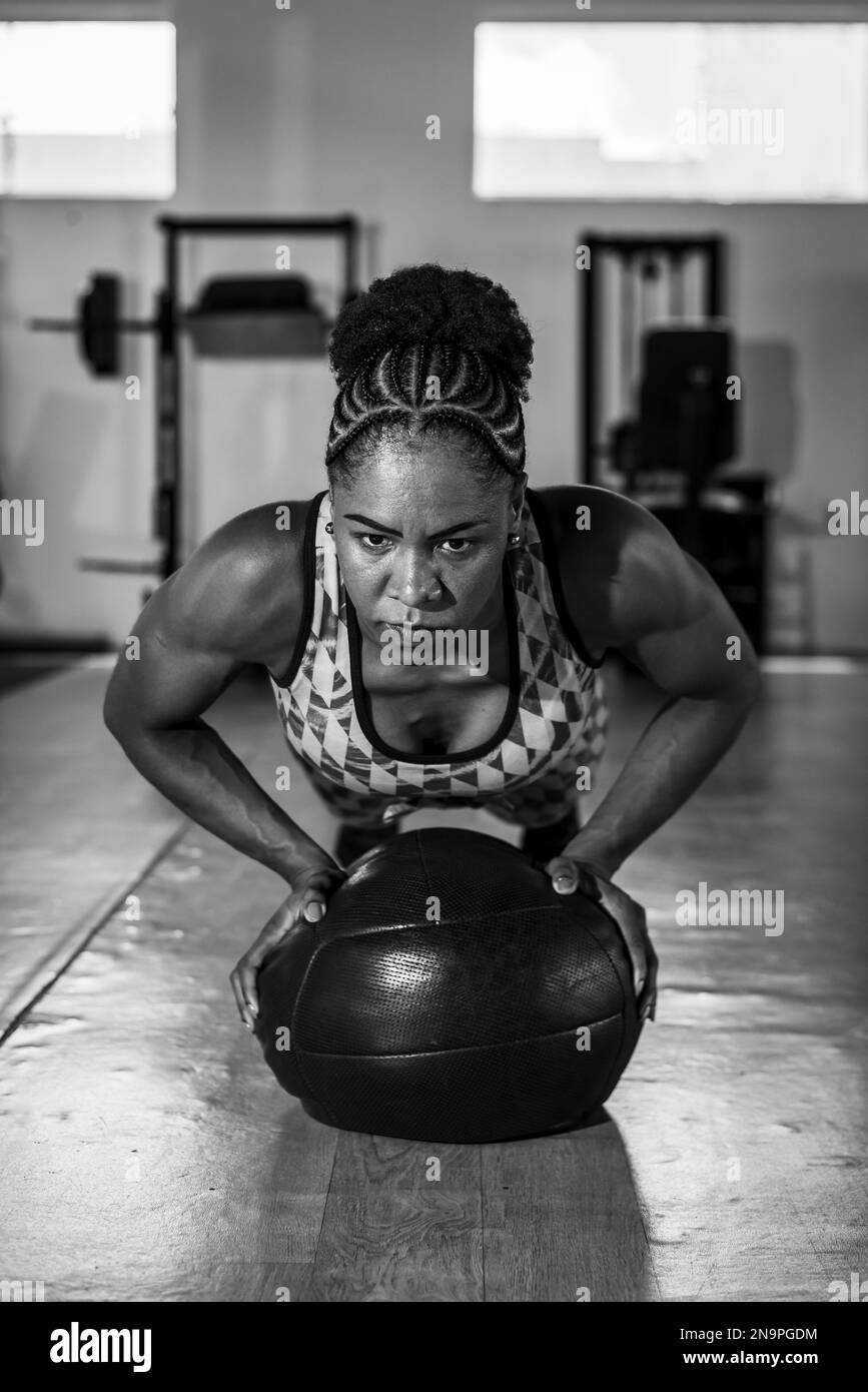 Determined woman doing support with a ball at the gym. Strengthening ...