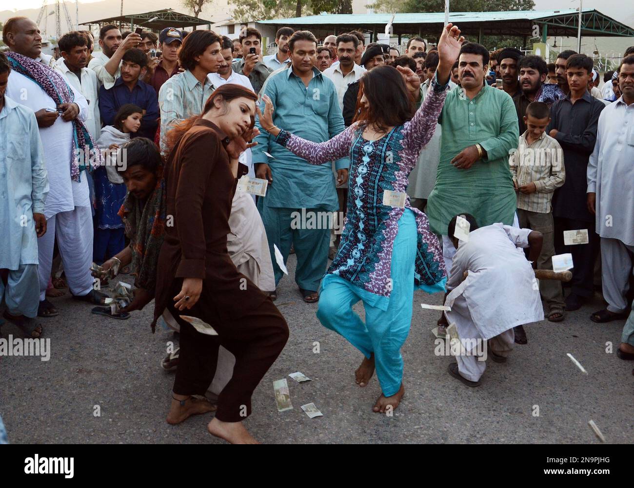 Pakistani eunuchs dance at a local shrine as people throw notes on them ...