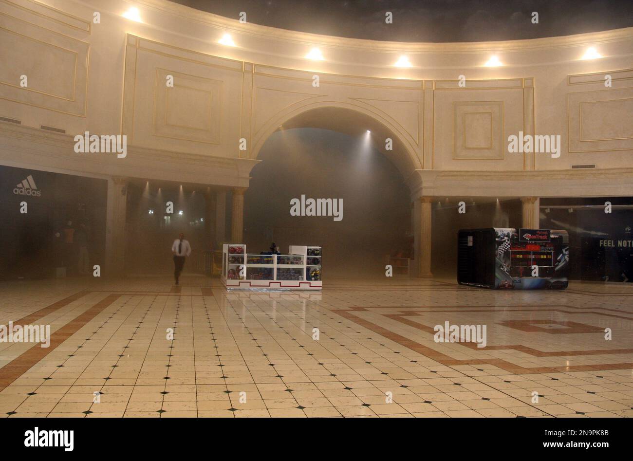 A man runs through smoke in the Villaggio Mall, in Doha's west end, as ...