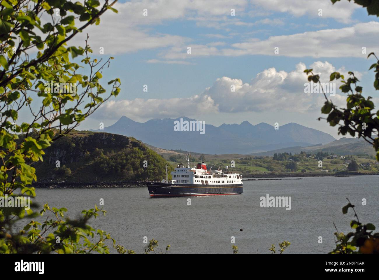 HEBRIDEAN PRINCESS underway in PORTREE BAY, with the dramatic backdrop ...