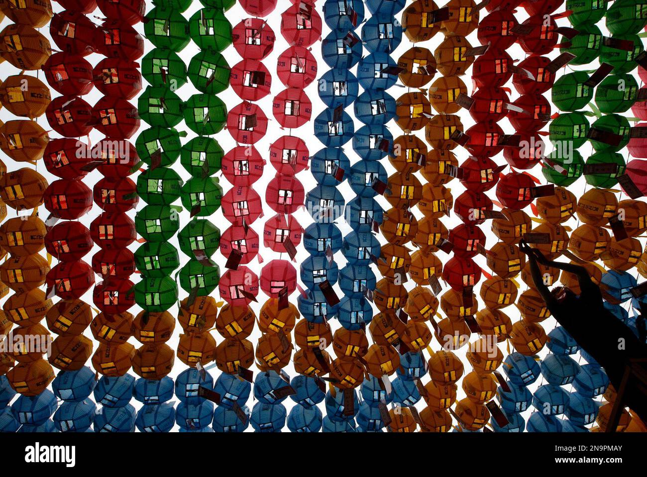 A worker attaches the name tags of a Buddhist to celebrate Buddha's ...