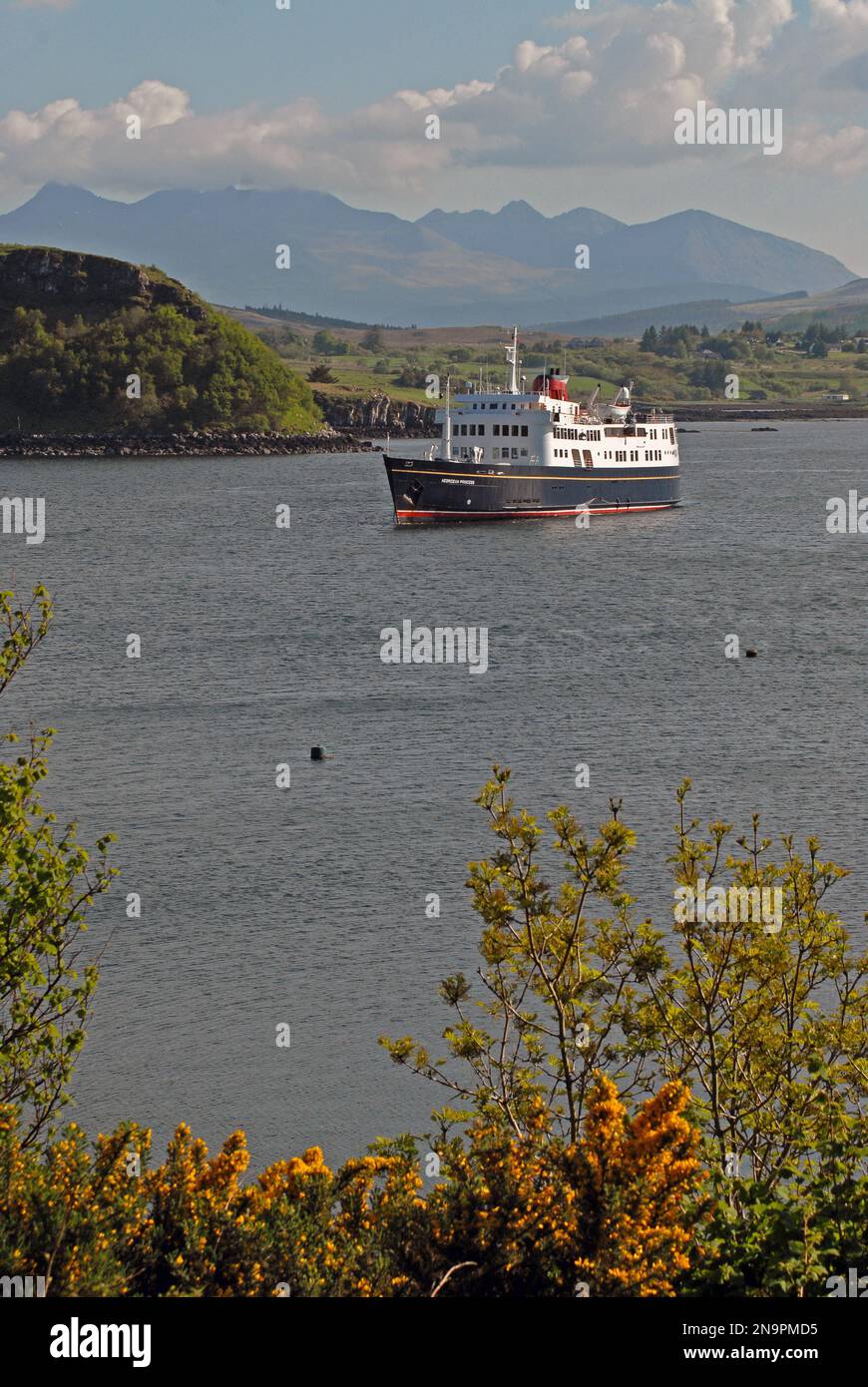 HEBRIDEAN PRINCESS underway in PORTREE BAY, with the dramatic backdrop ...