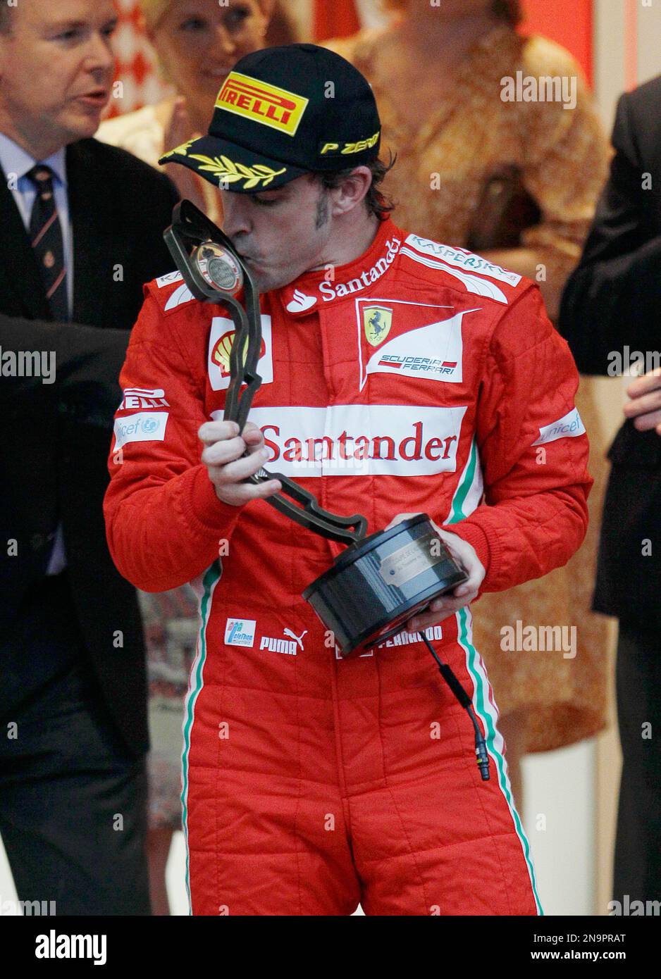 Ferrari driver Fernando Alonso, of Spain, kisses a trophy after taking ...