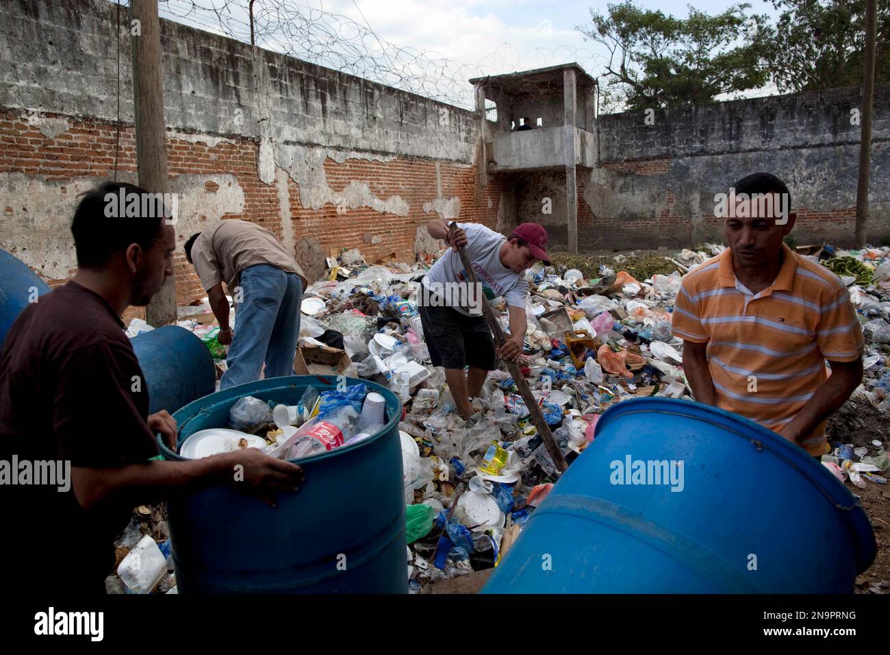 In this May 2, 2012 photo, inmates take the trash out from their cells ...