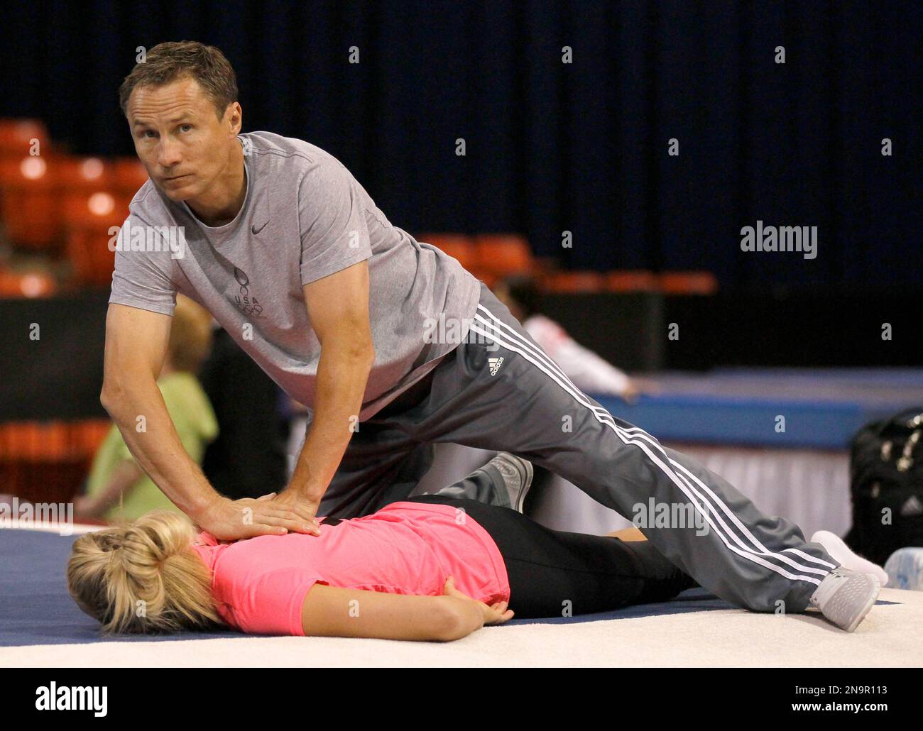 Gymnastics coach Valeri Liukin stretches his daughter Nastia during a ...