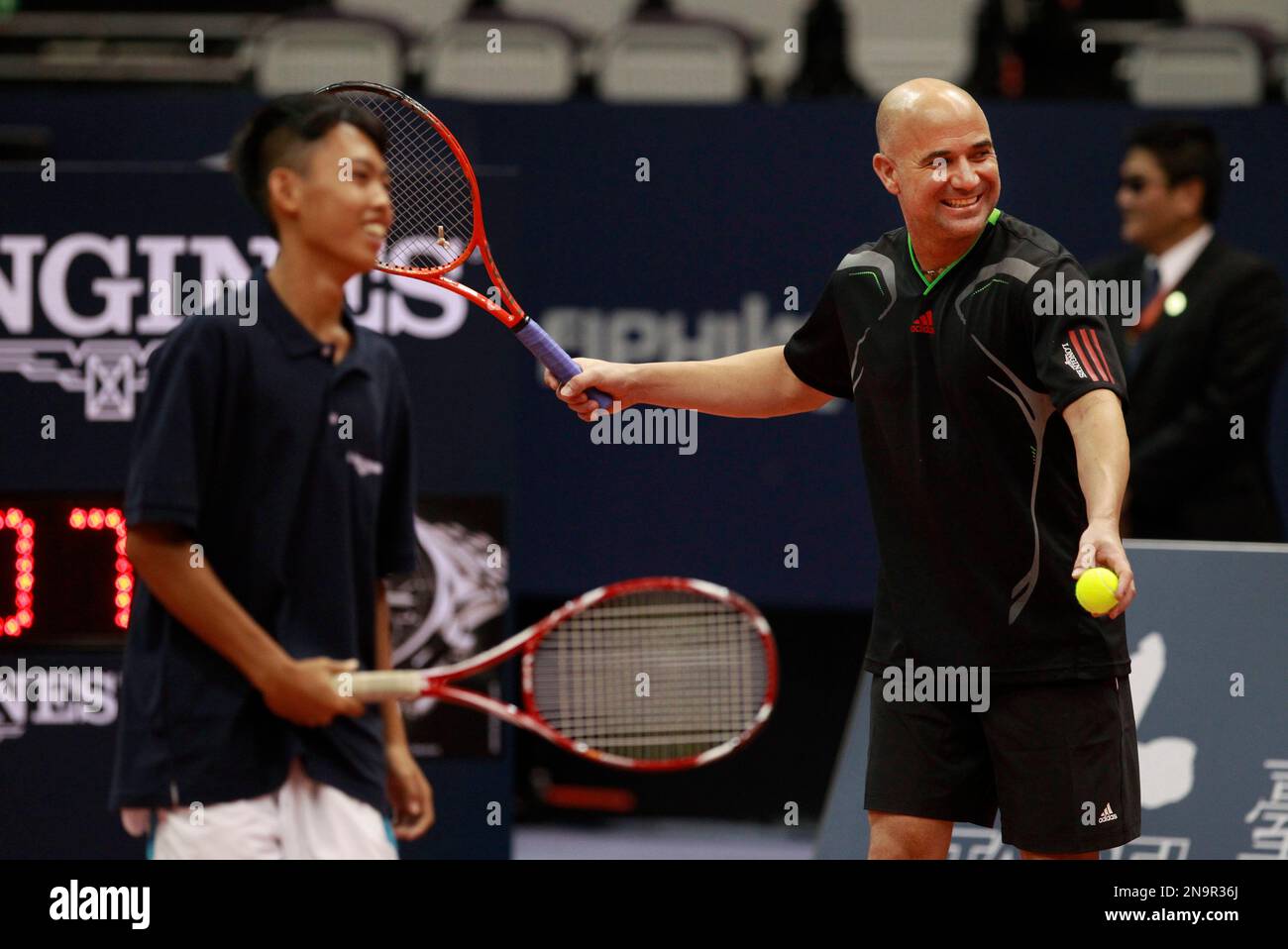 Former American tennis star Andre Agassi smiles as he holds a "Rise of ...