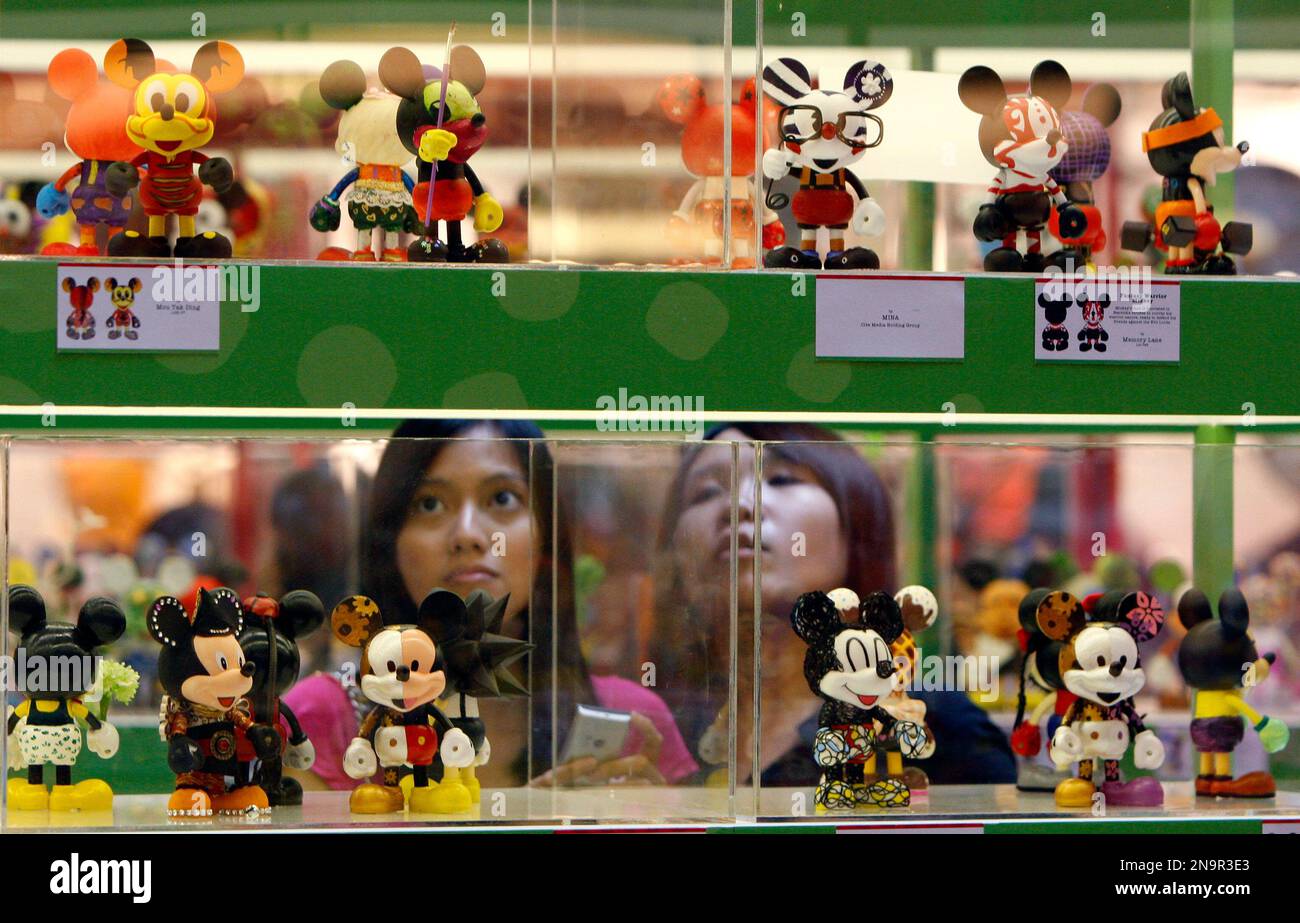 Visitors look at Mickey Mouse dolls on display during "Mickey Mouse ...