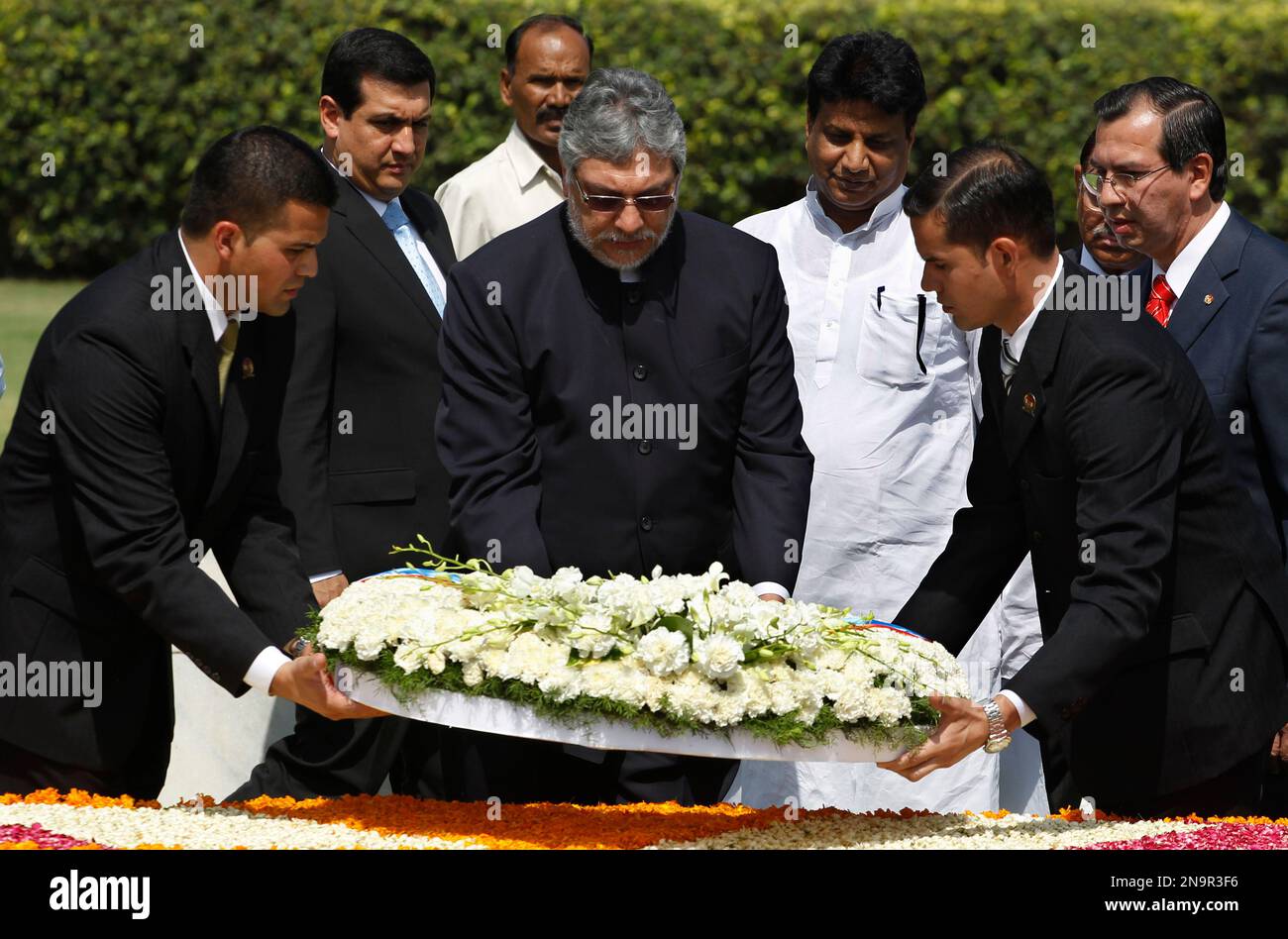 Paraguay President Fernando Lugo Mendez, center, offers flowers at the ...